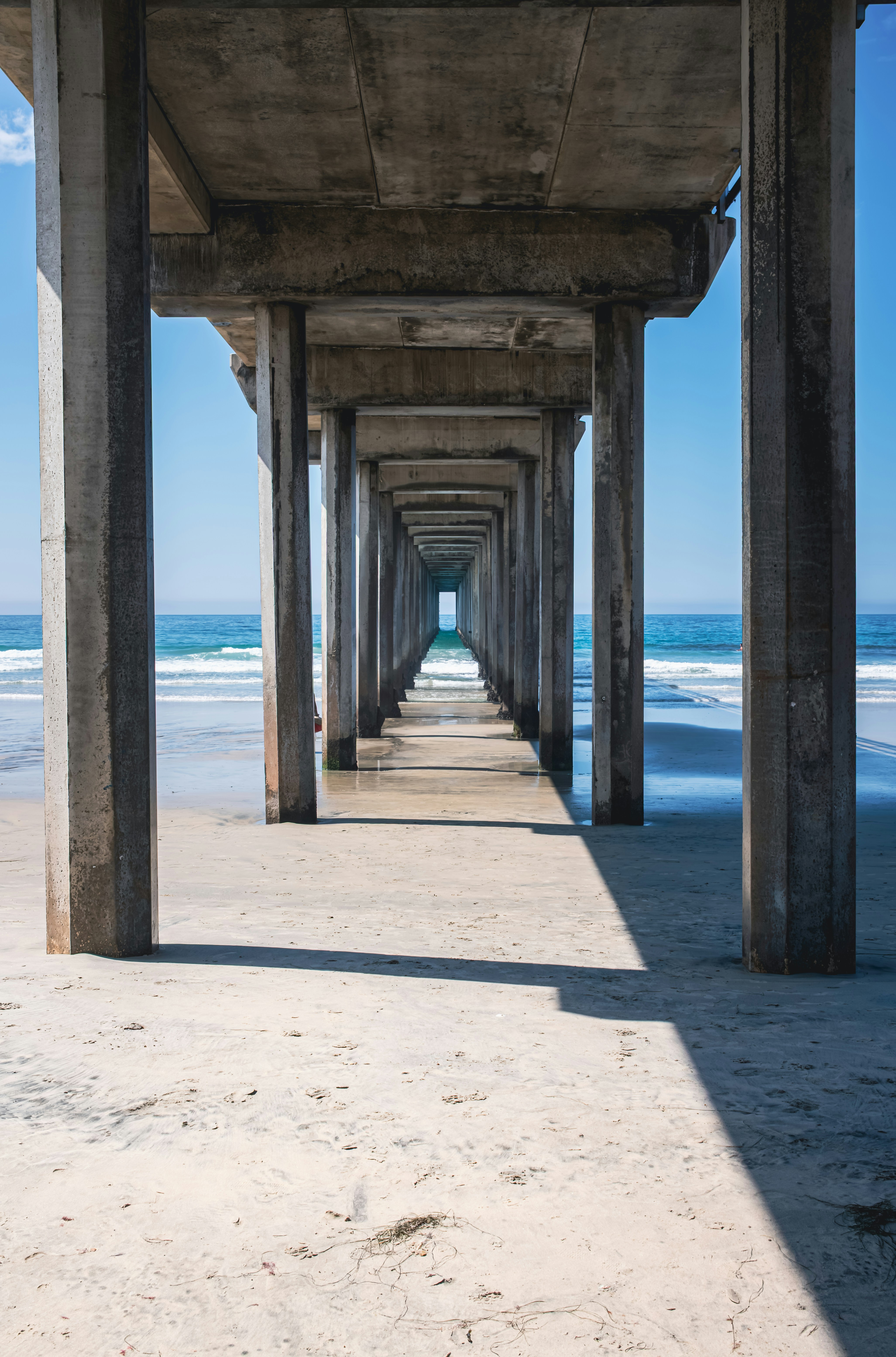 Pierway Corridor: A Tunnel of Receding Columns over Sunlit Sand