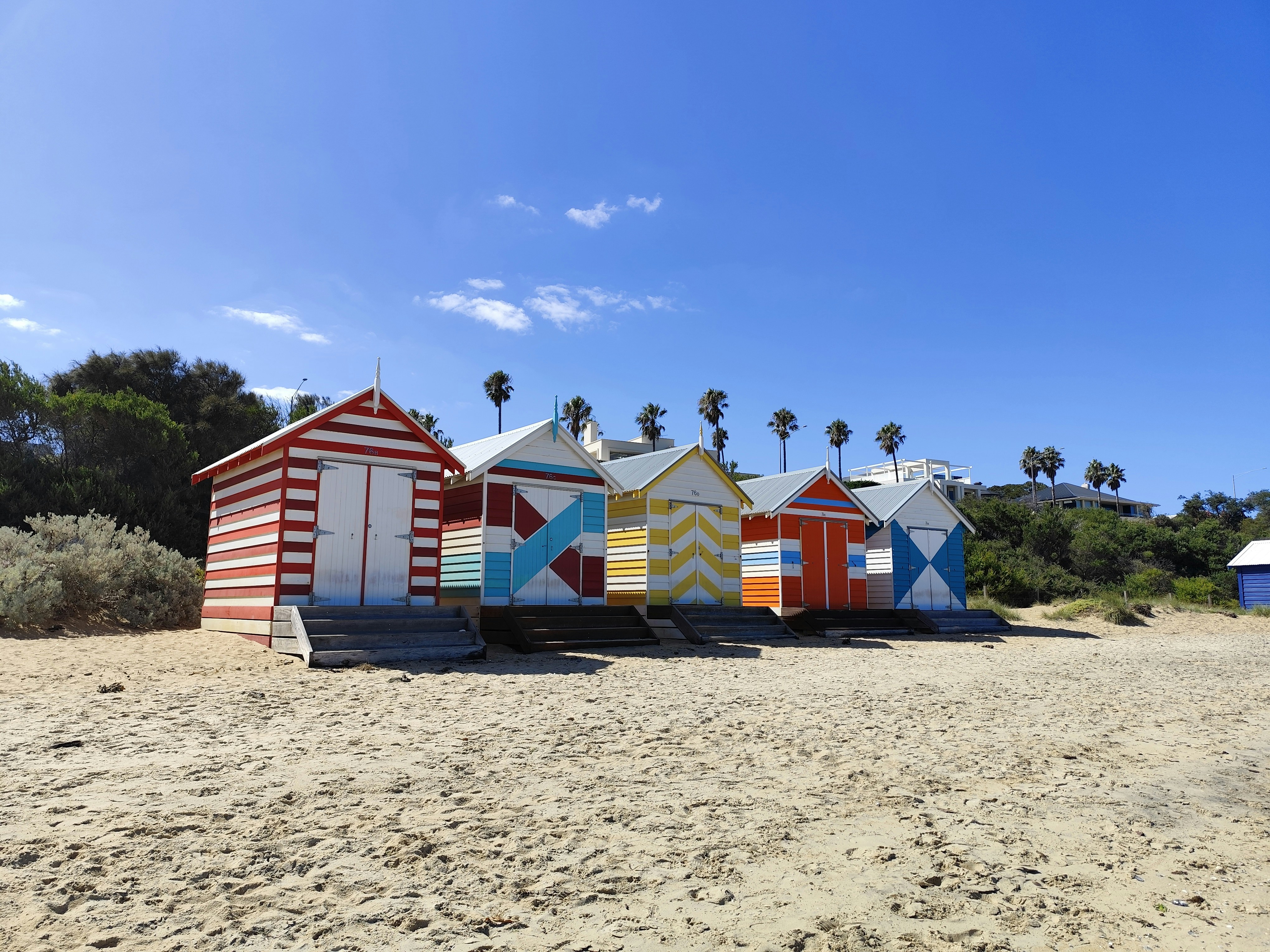 Colorful Beach Cabins Stand Tall Against a Clear Blue Sky