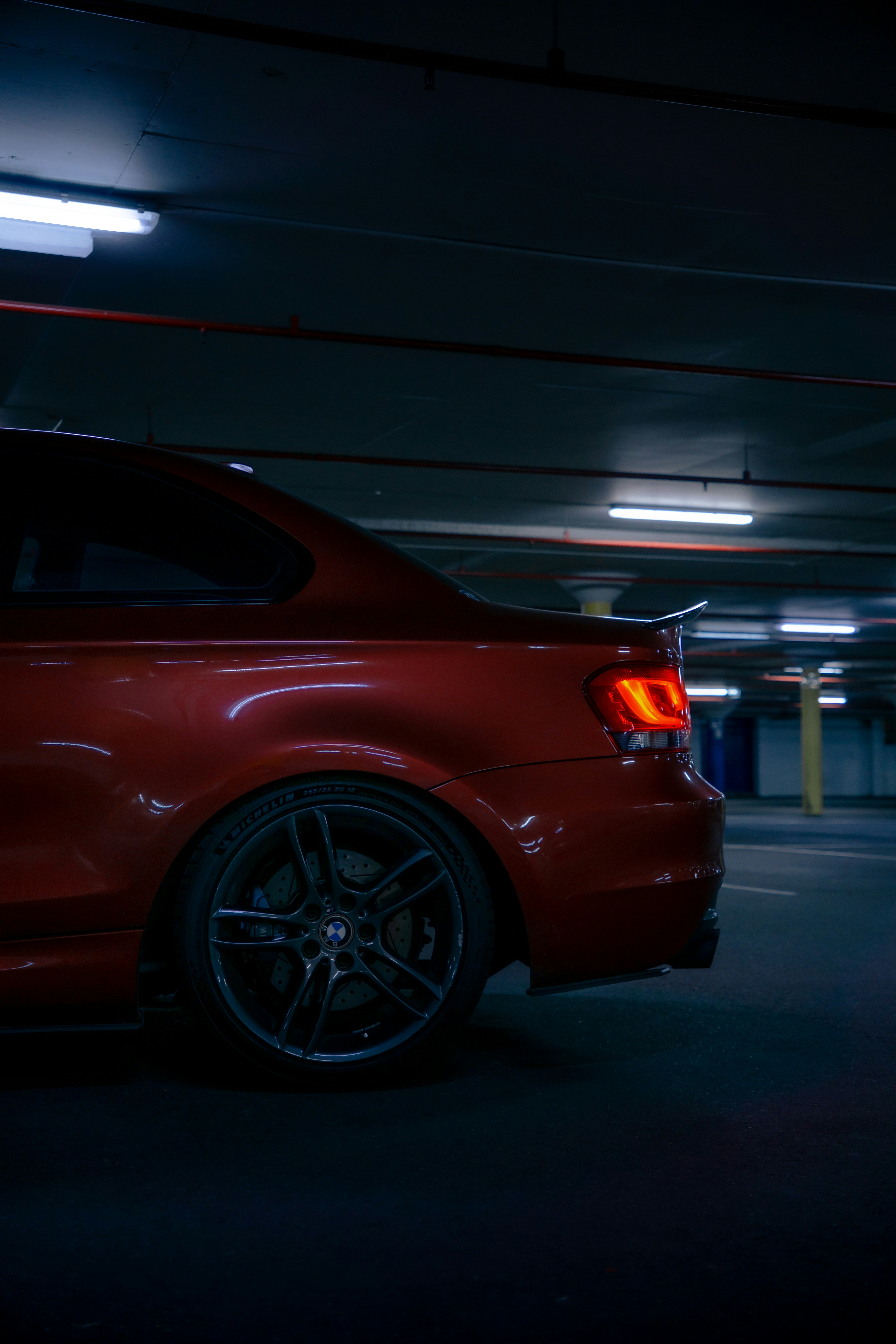 Red rear quarter silhouette: a car in an urban underground glow
