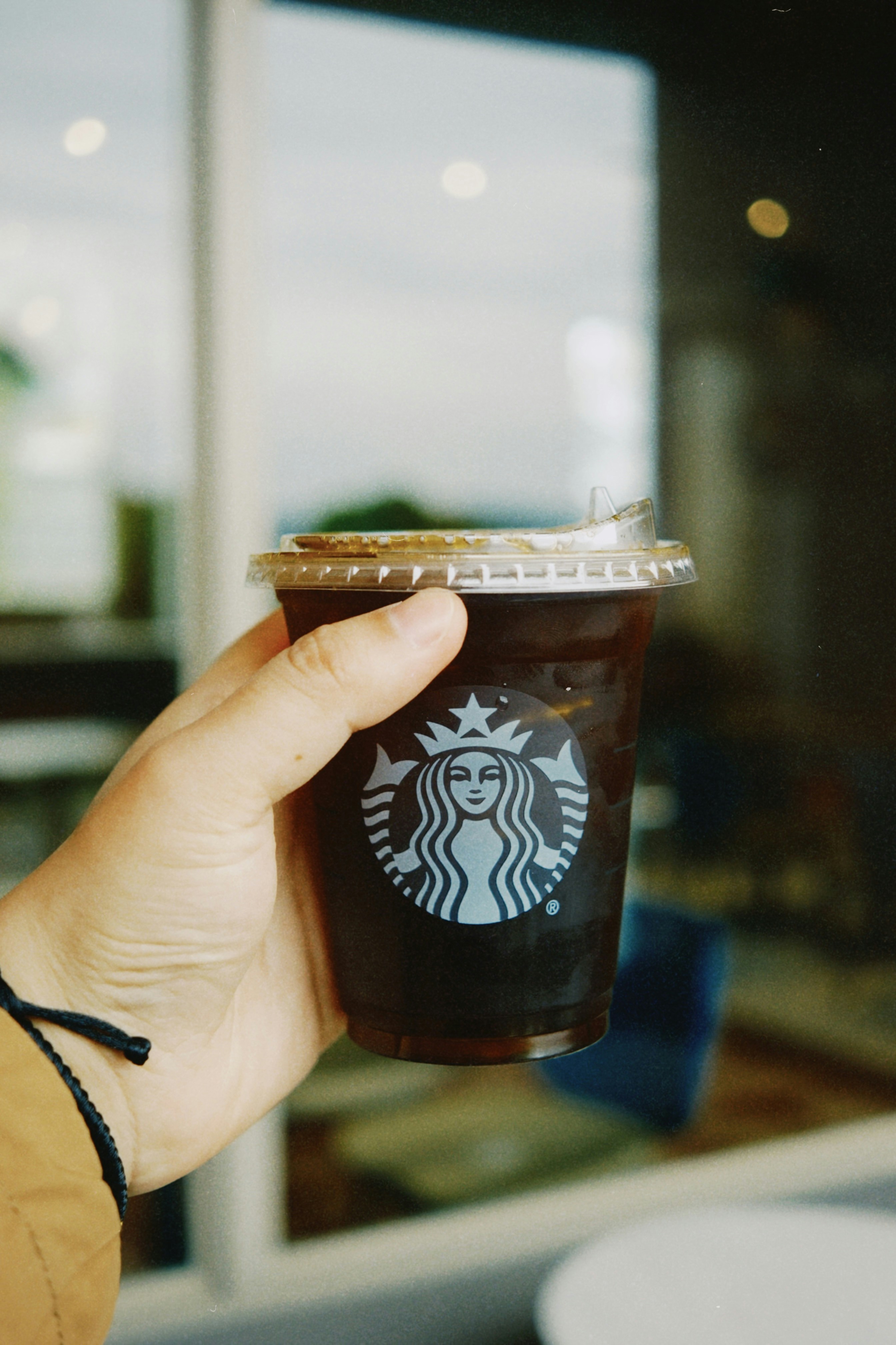 Starbucks Gaze: A Cold Brew Crowned by Hand and Glass