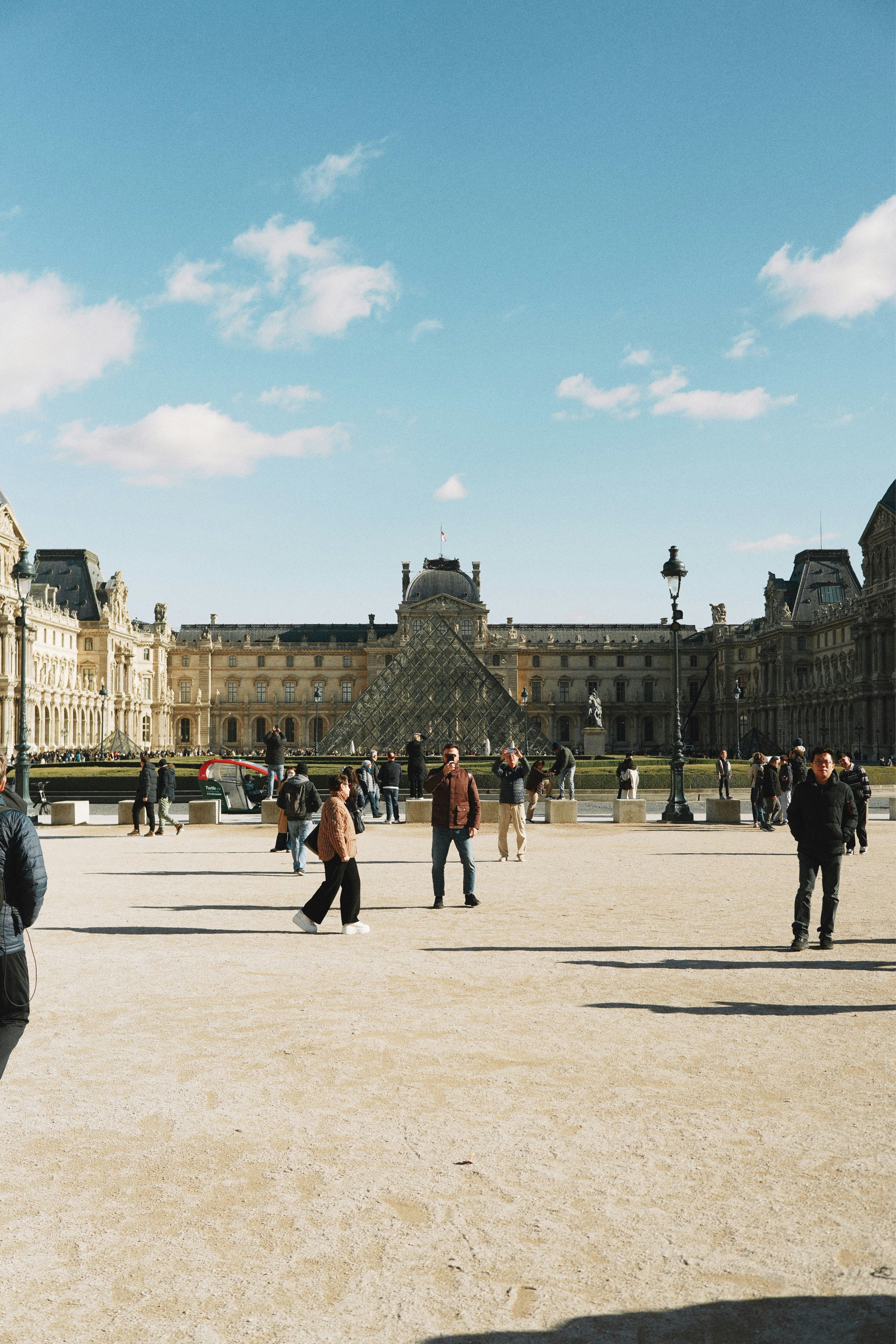 Courtyard of Louvre: People, Pyramid, and Classical Facades in daylight