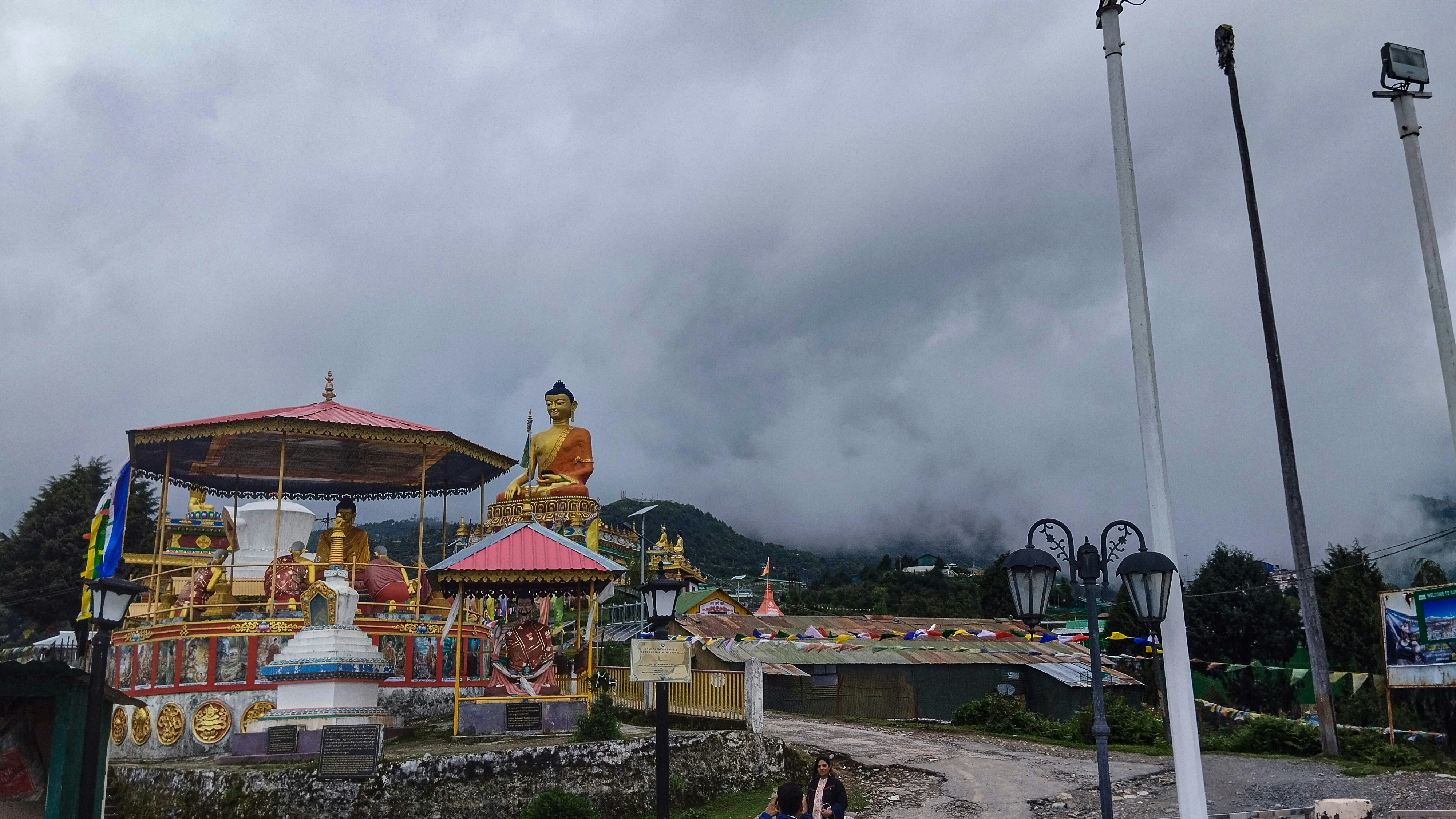 Temple Terrace in Mist: Golden Statues Beneath Varied Clouds