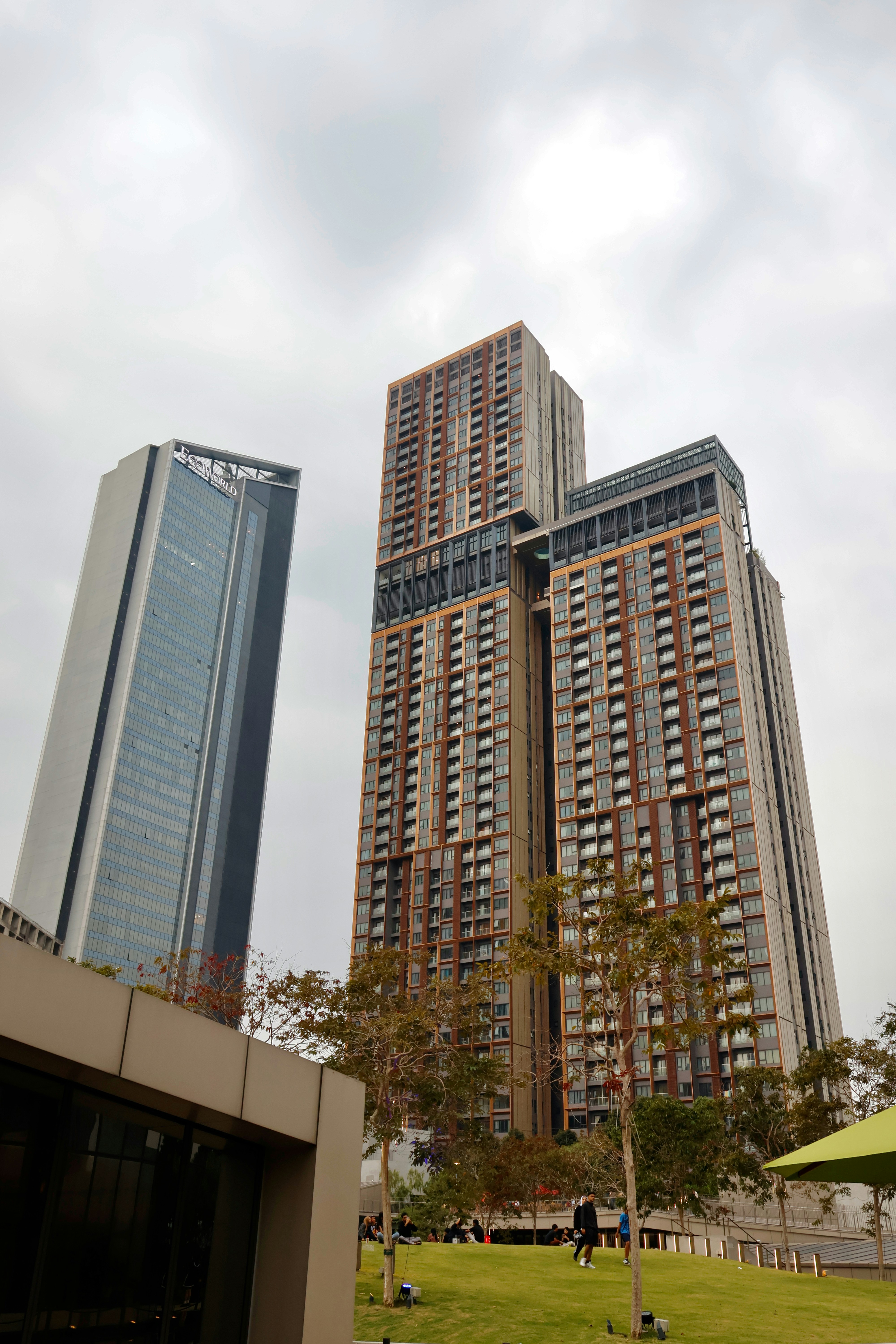 Vertical Cityscape: Twin Towers Rise Over a Quiet Park