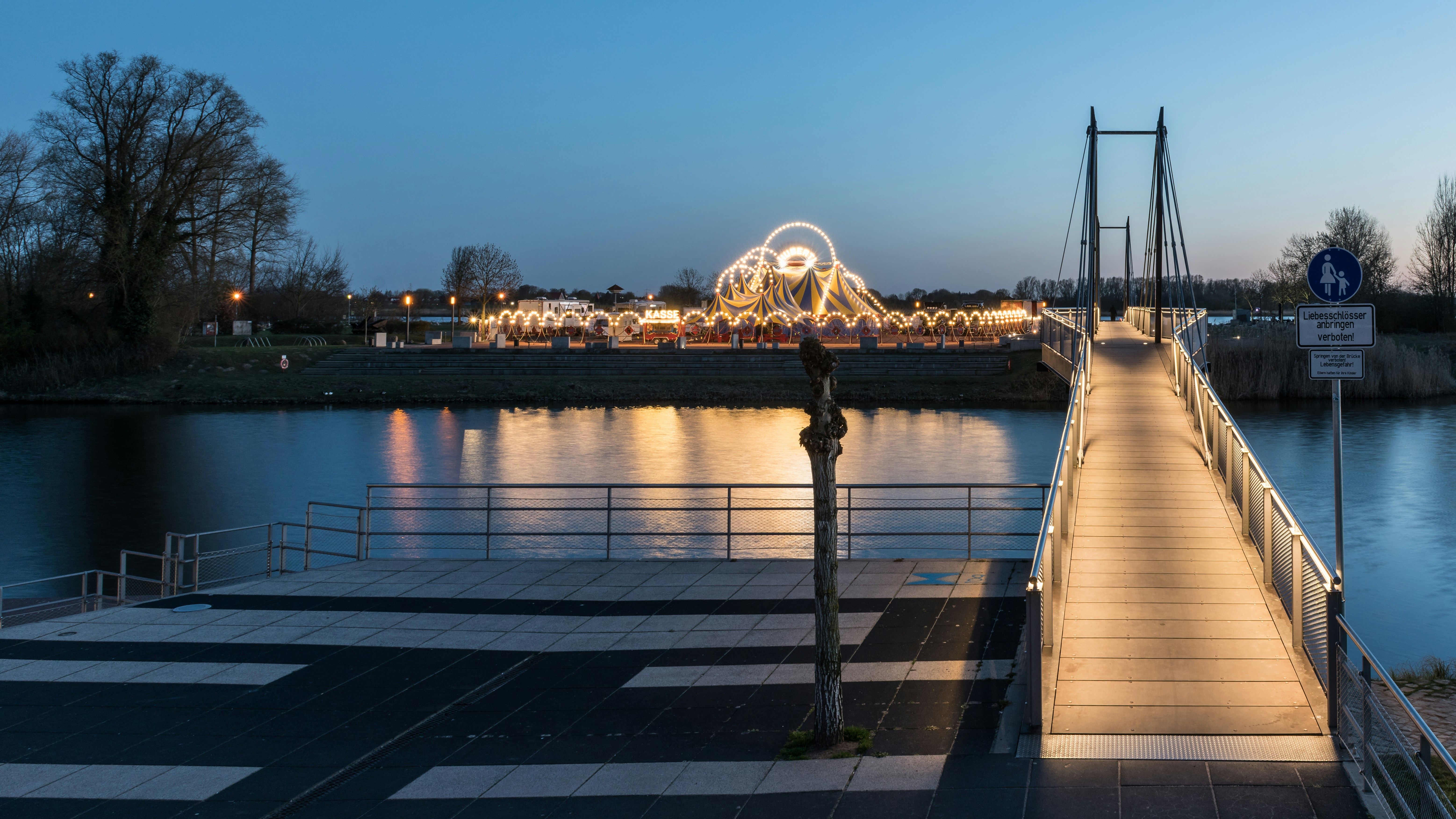 Glowing Bridge at Dusk: A Quiet Riverside Walkway