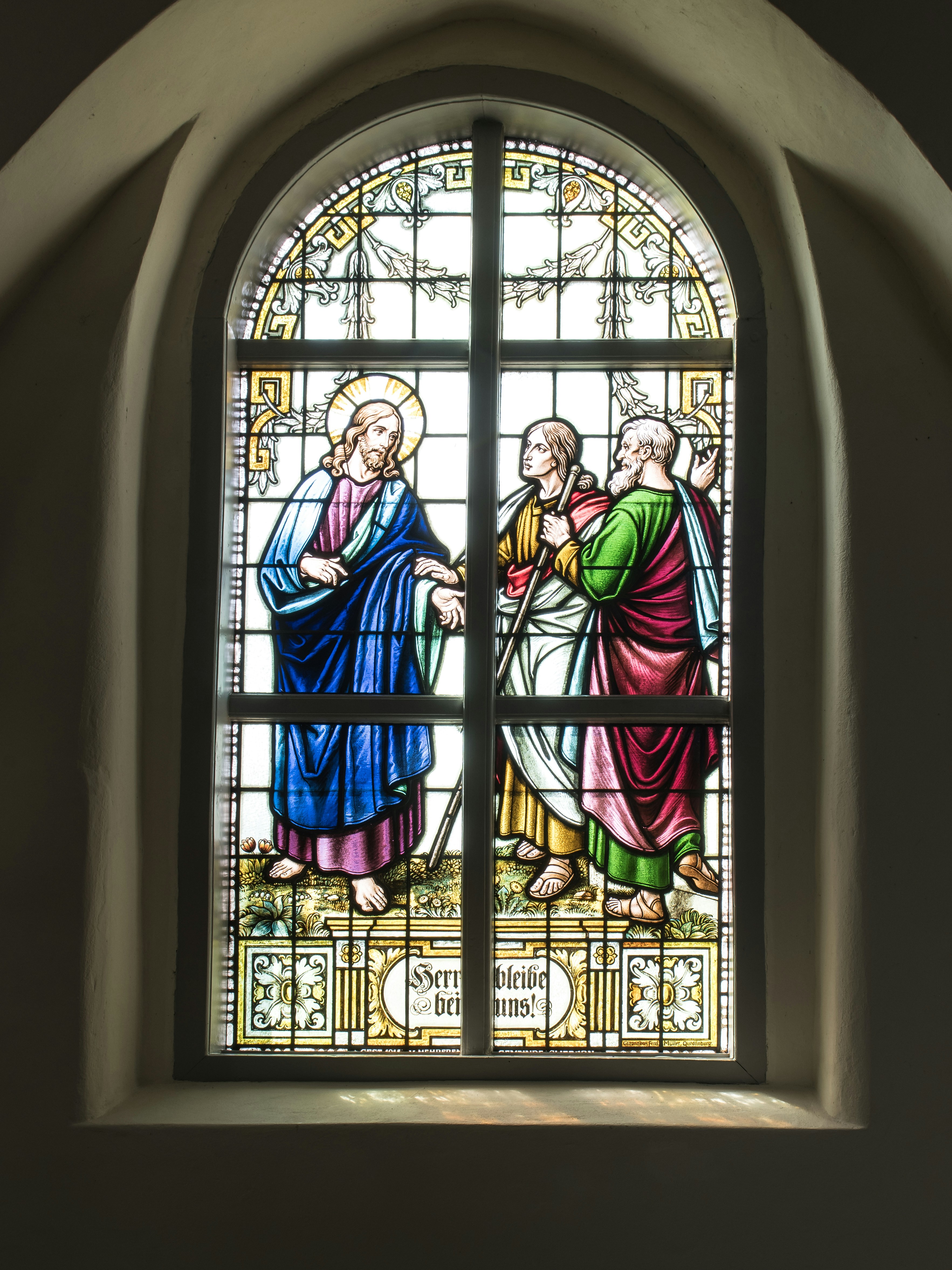 Stained glass window depicting jesus and two disciples.
