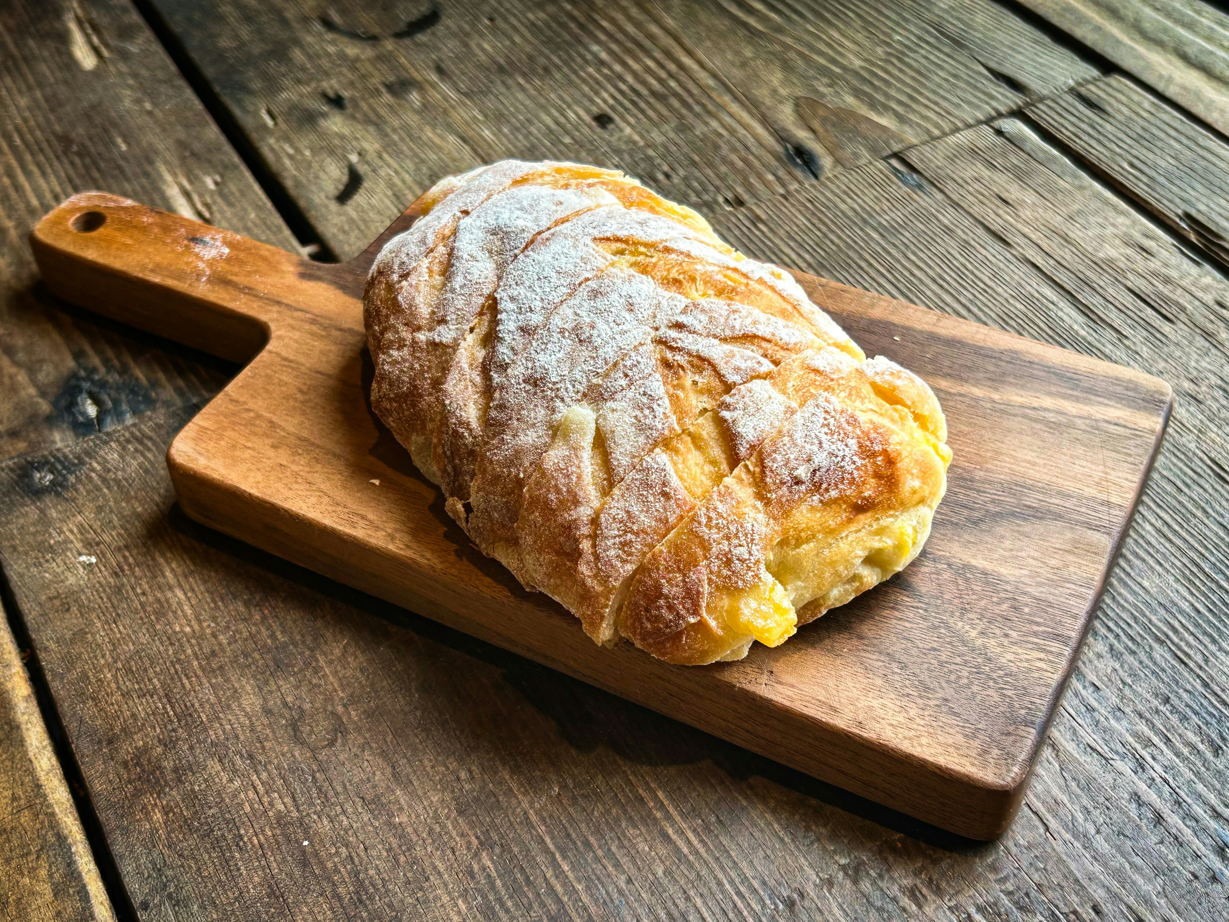 Crusty Cream-Filled Roll on a Rustic Board