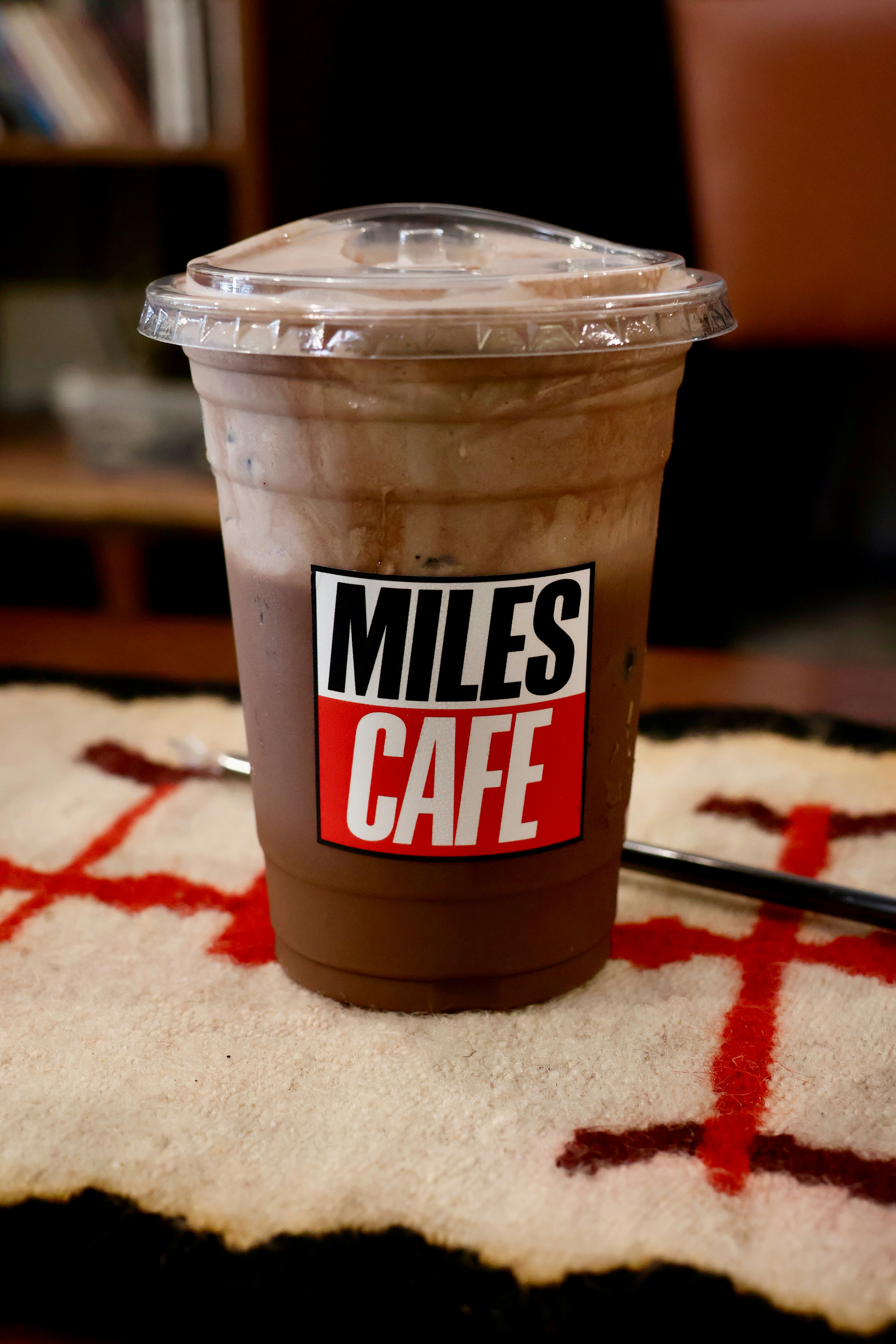 Iced chocolate drink from miles cafe on a patterned rug.