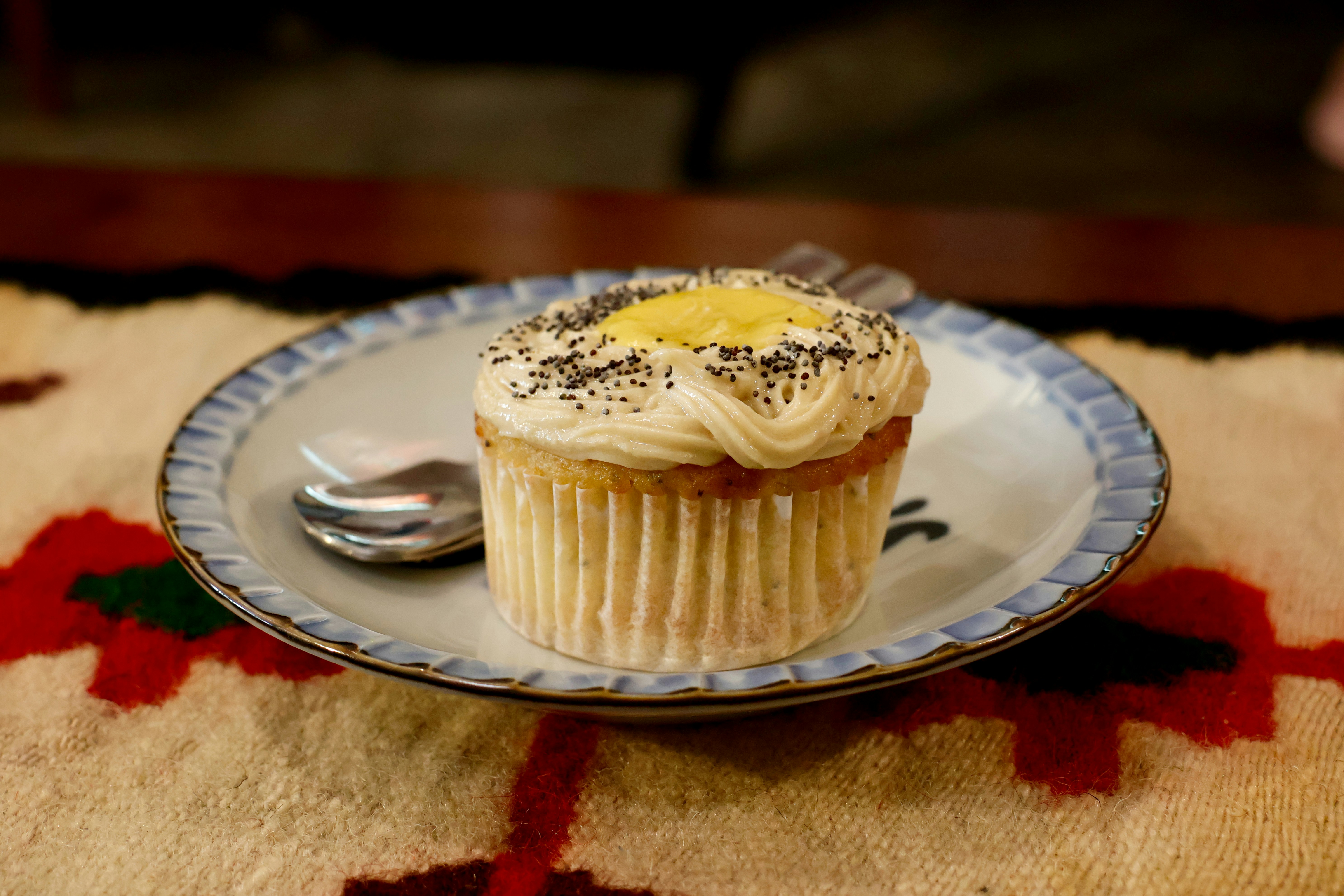 Cream-Topped Cupcake on a Plate: Center Stage on a Cozy Tablecloth