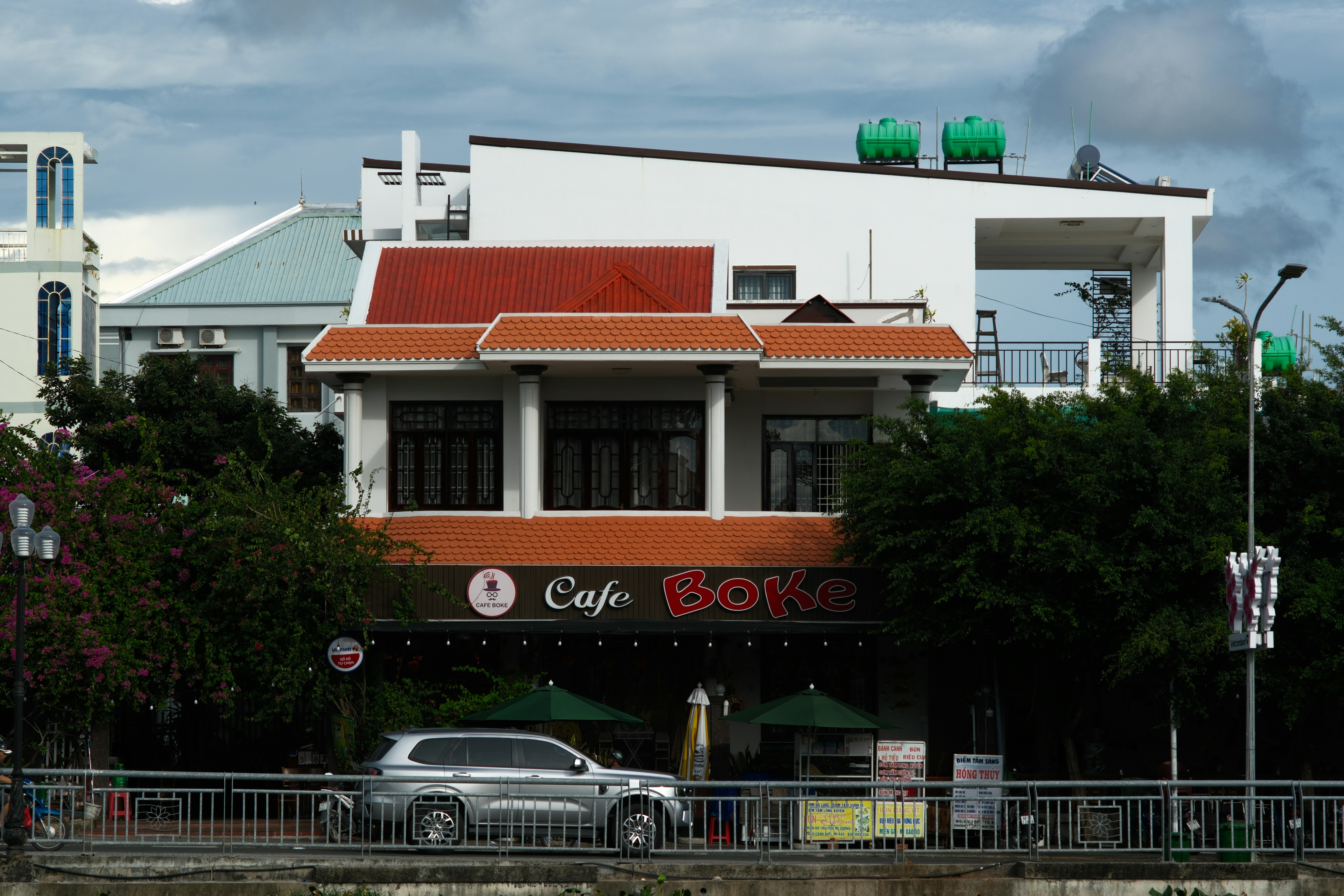 Cafe BoKe: A Quiet Riverside Corner with Red Roof and Green Umbrellas