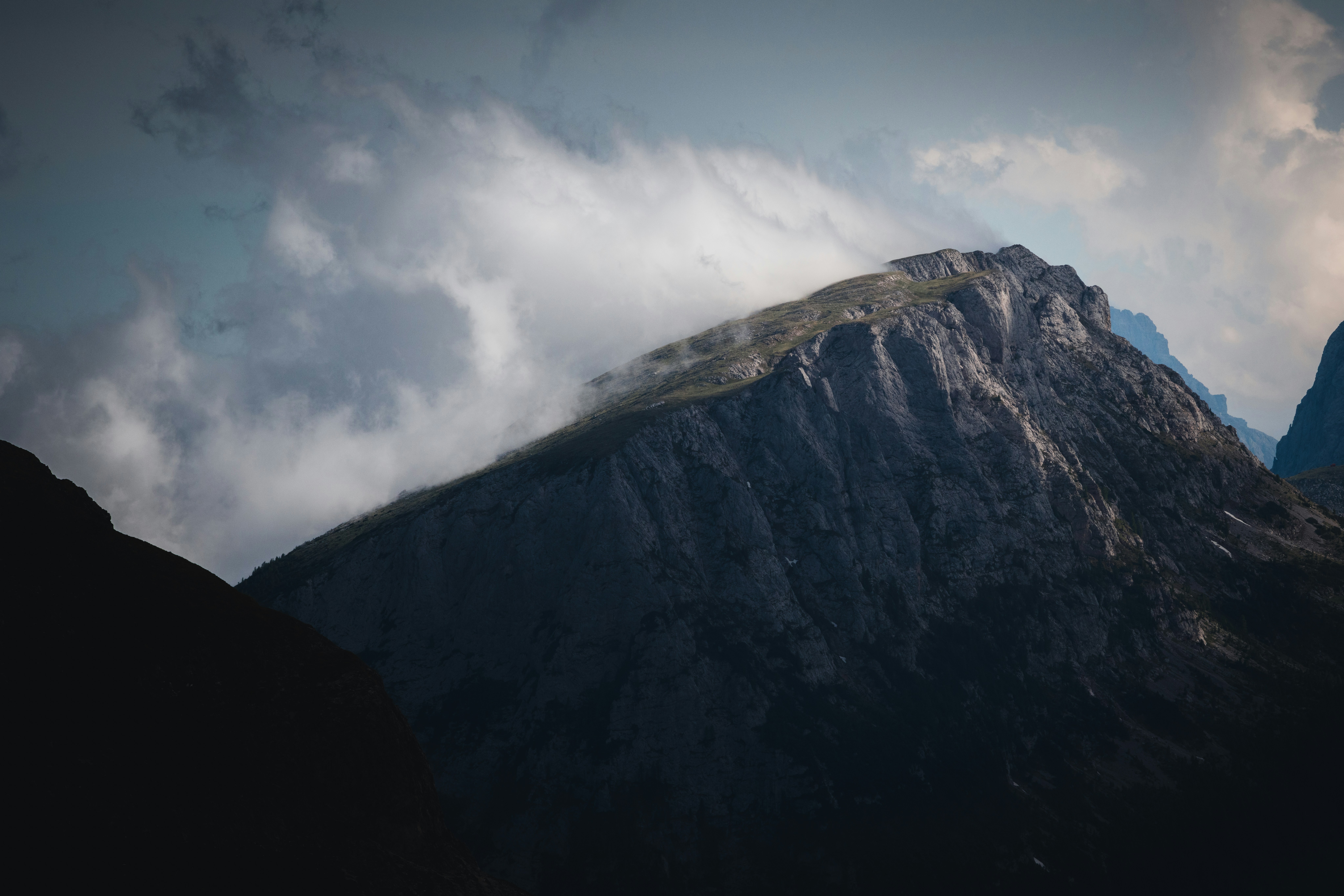 Majestic mountain peak shrouded in dramatic clouds and shadows.