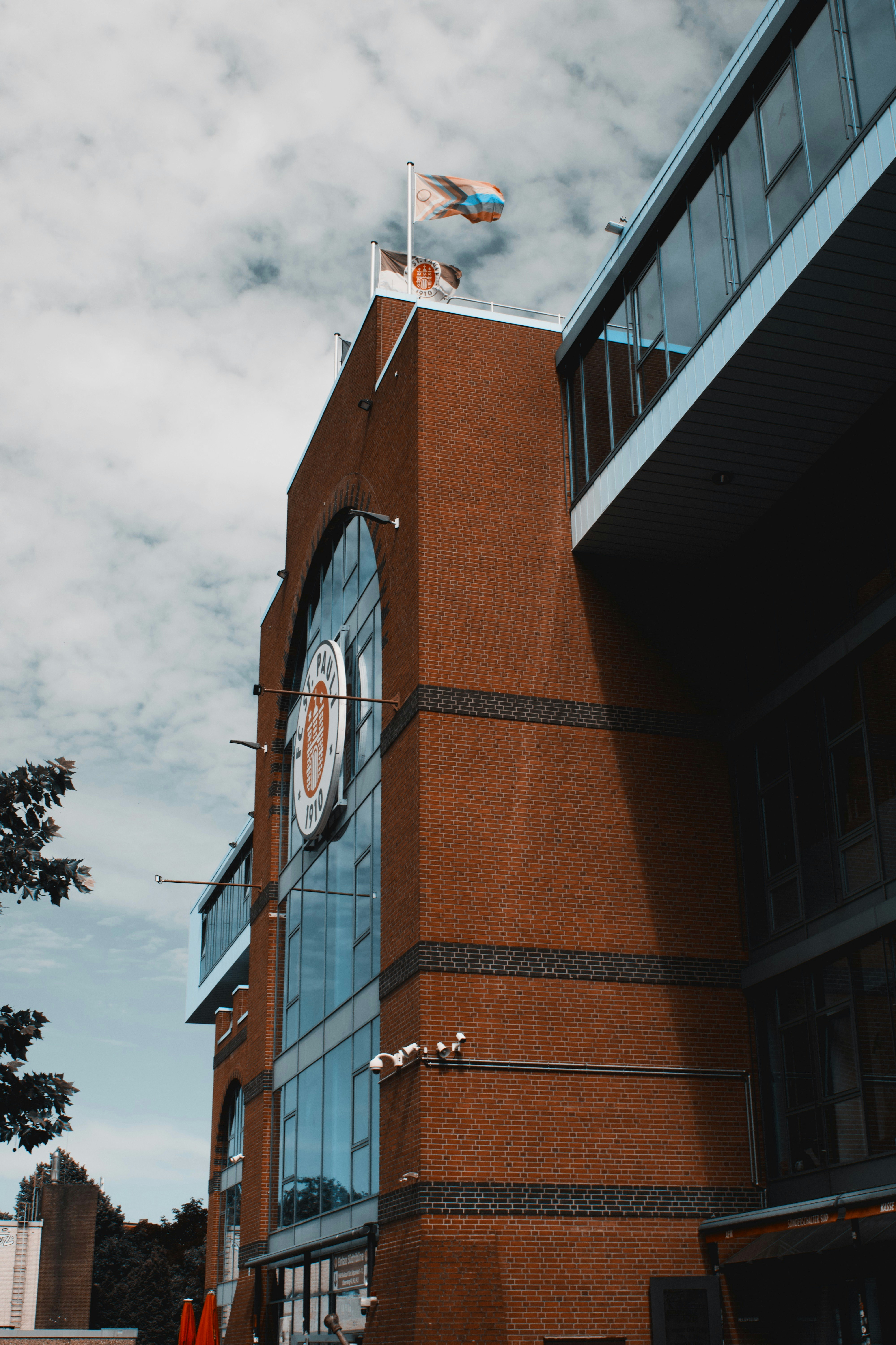 Brick Clocktower Rising: A Modern Campus Facade Under a Stratus Sky