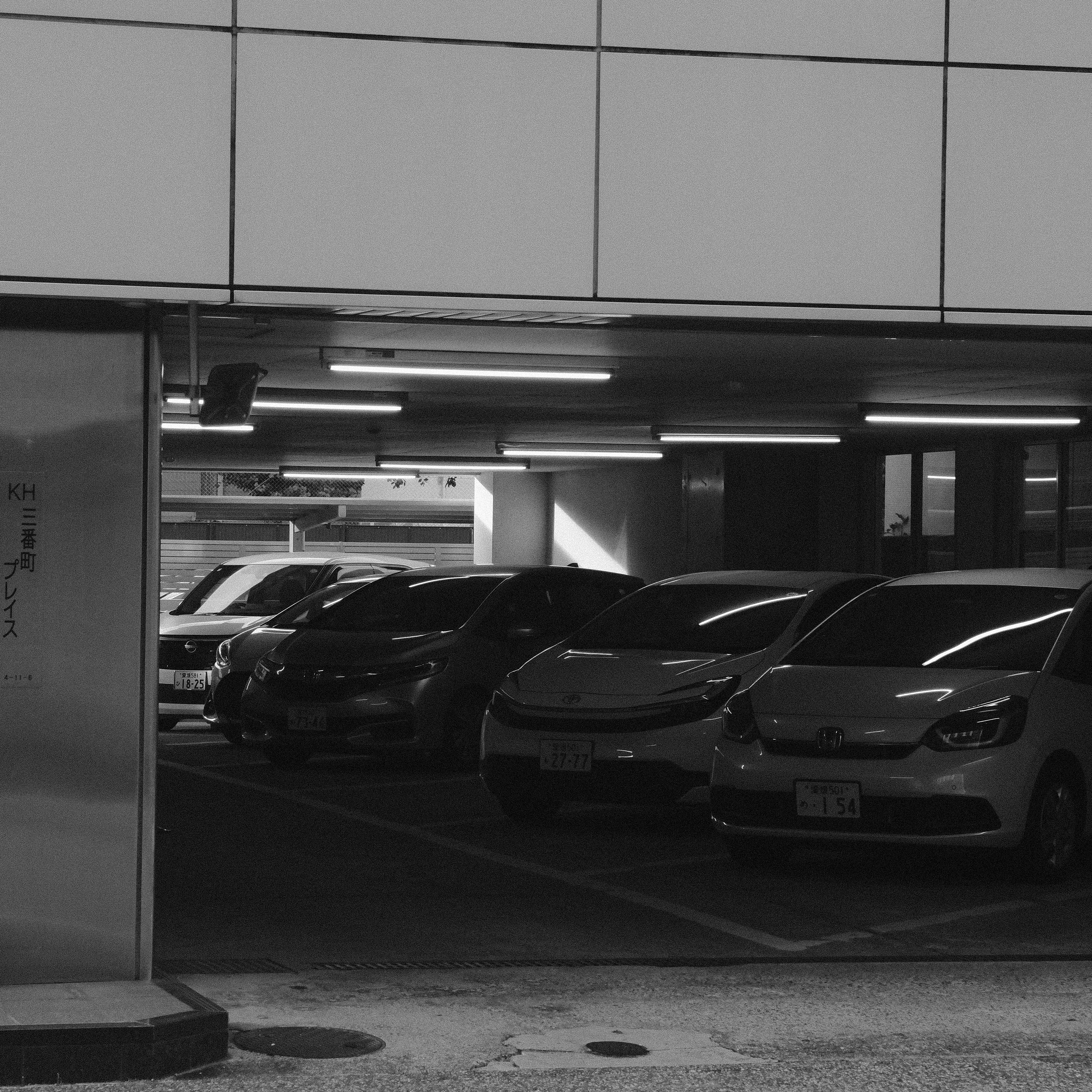 Midnight Lot: Cars Rest Under Fluorescent Veins