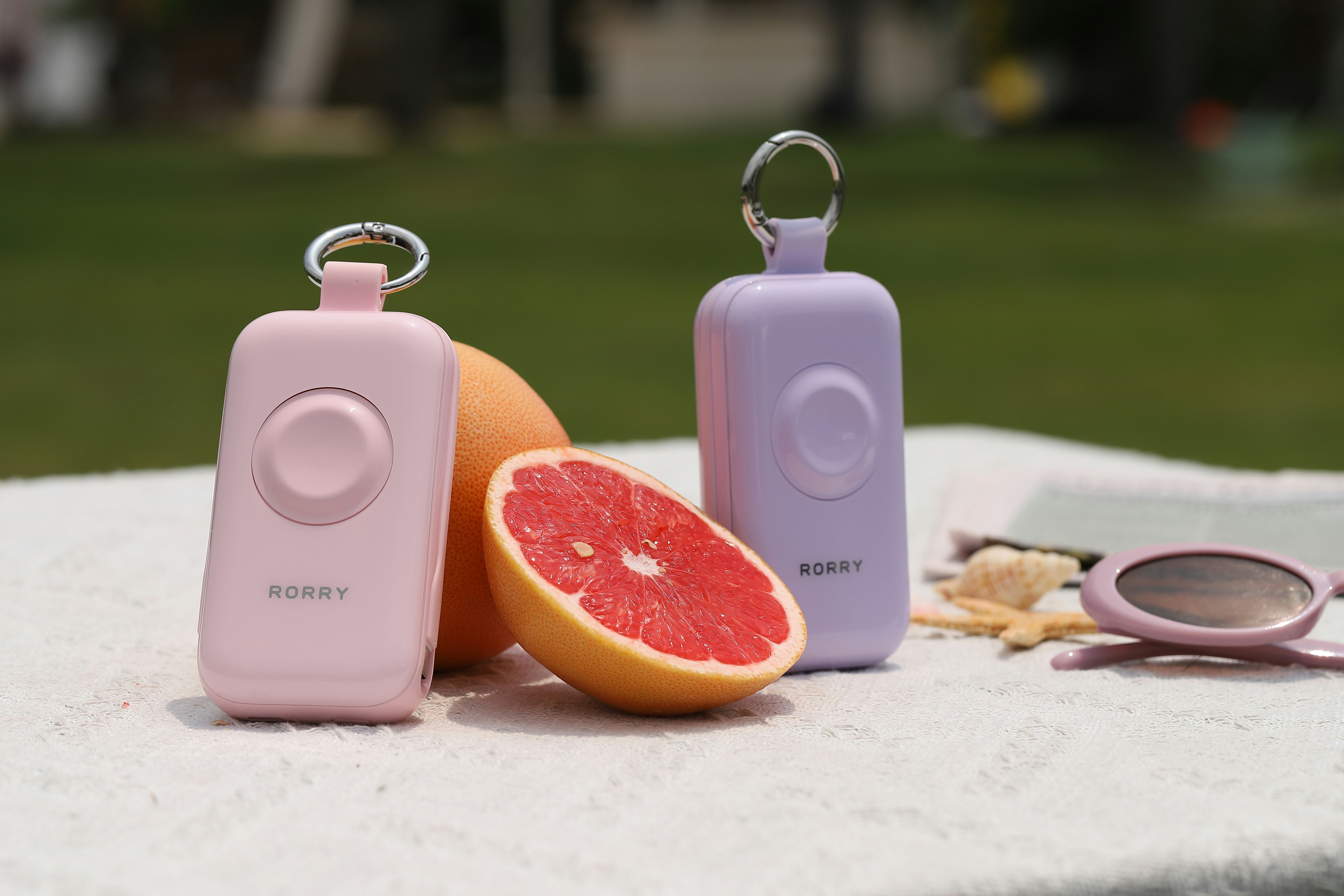 Pastel keychain duo with grapefruit slice in crisp daylight