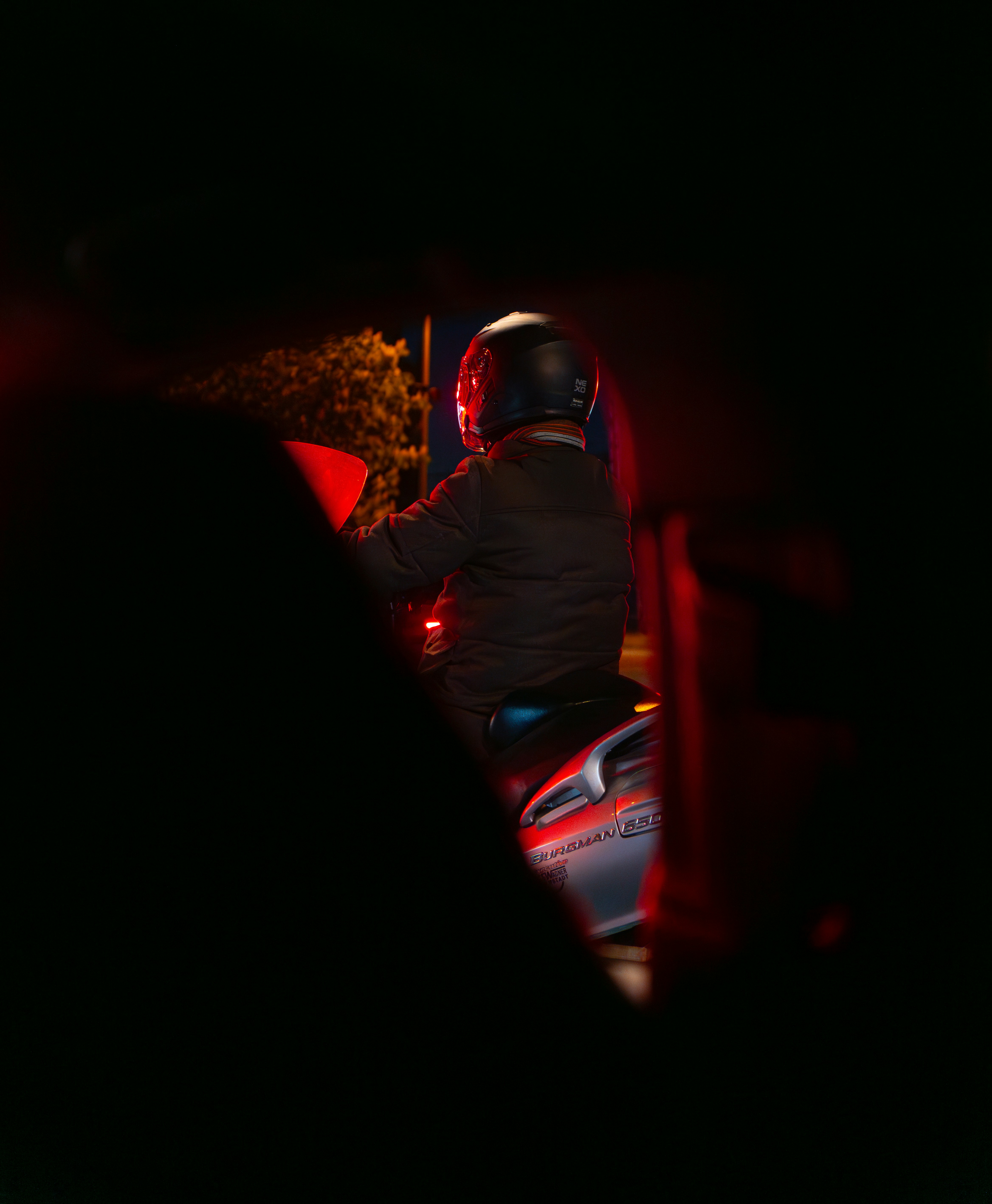 Night Ride: Rider Backlit by Red Cabin Lights