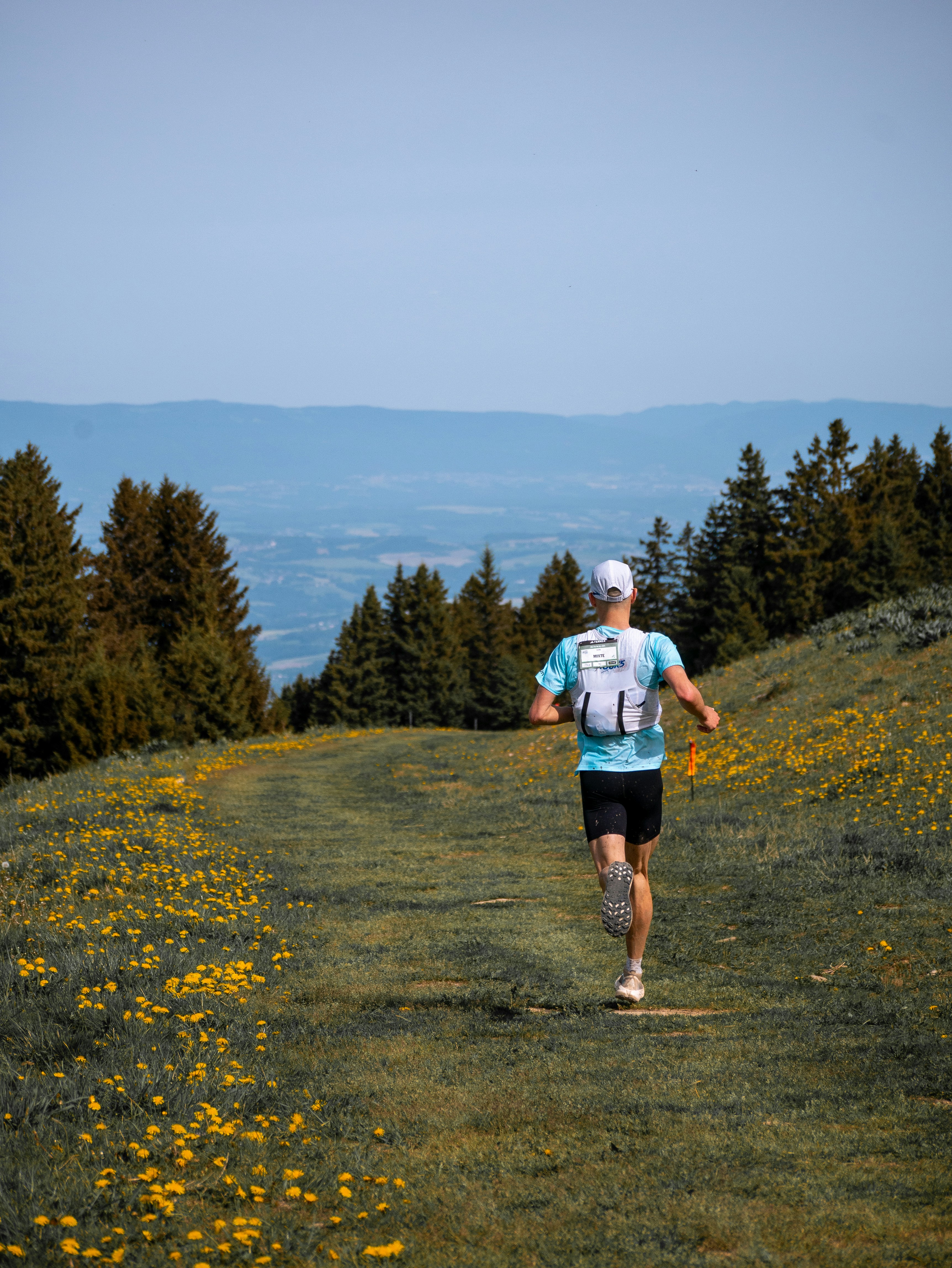 Trail Runner Amid Wildflower Sea under a Quiet Sky