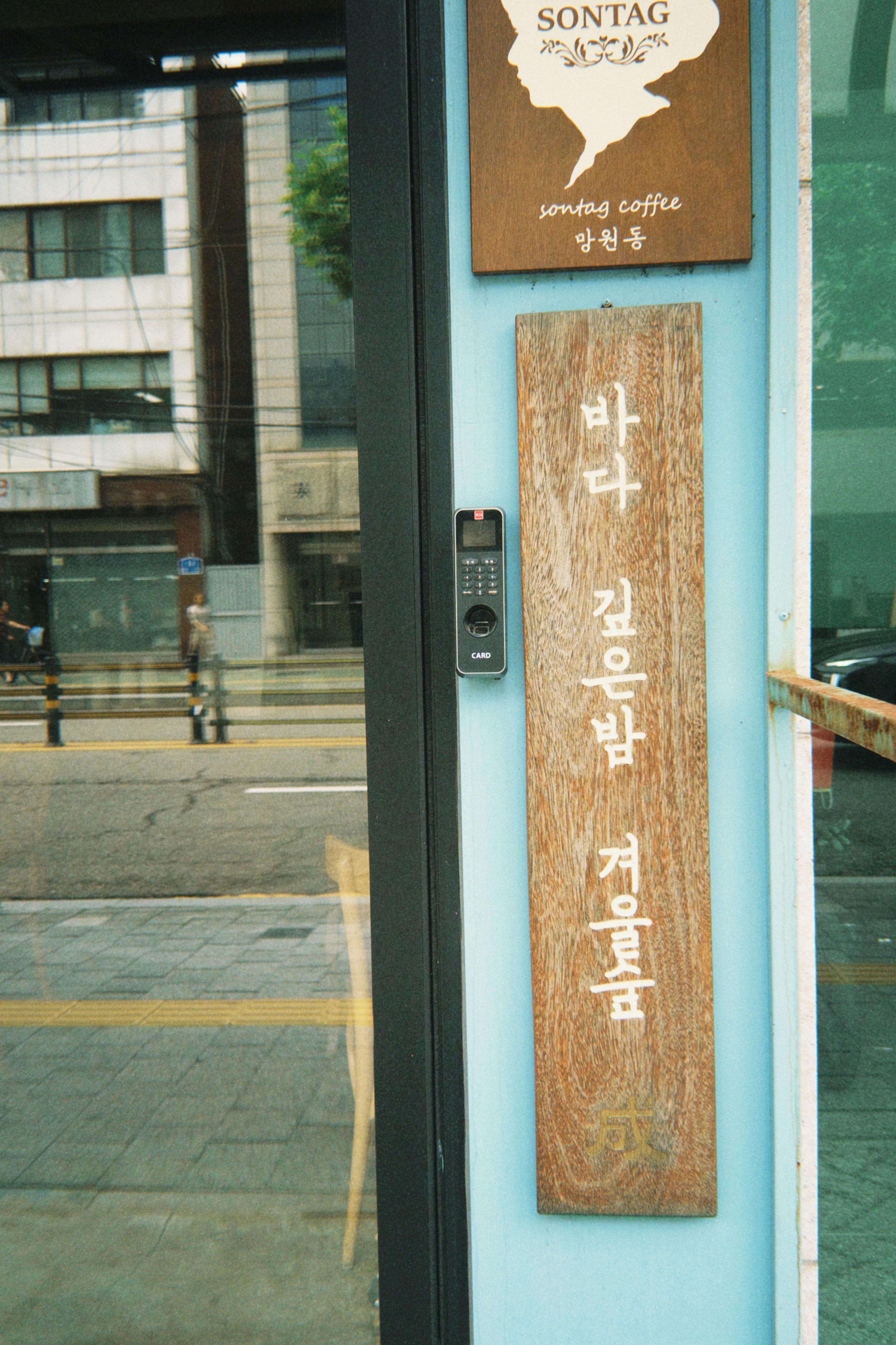 Cafe Sign and Doorline: A Quiet Street View Through Glass