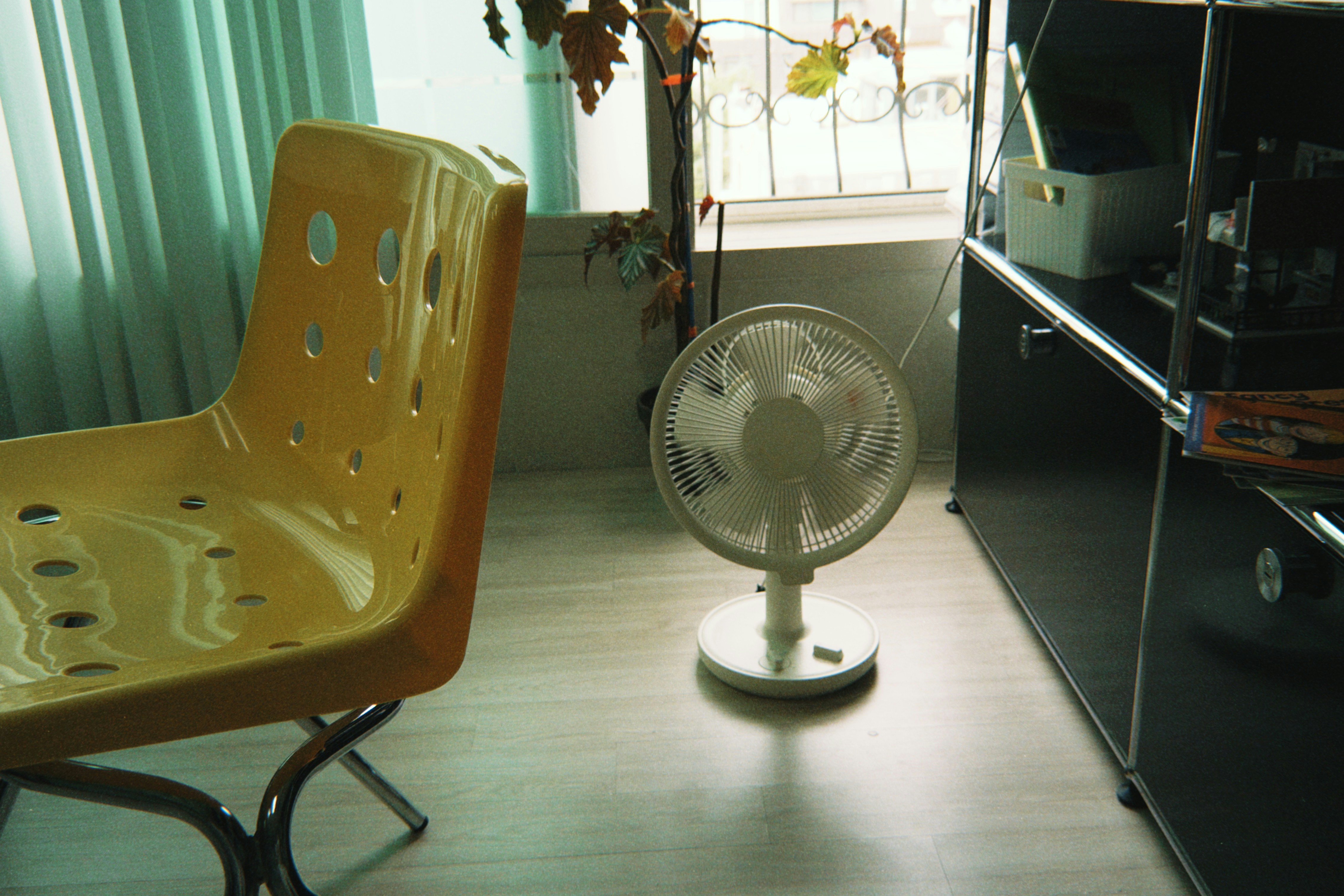 Midcentury Quiet: A Sparse Corner with a Fan and Yellow Chair