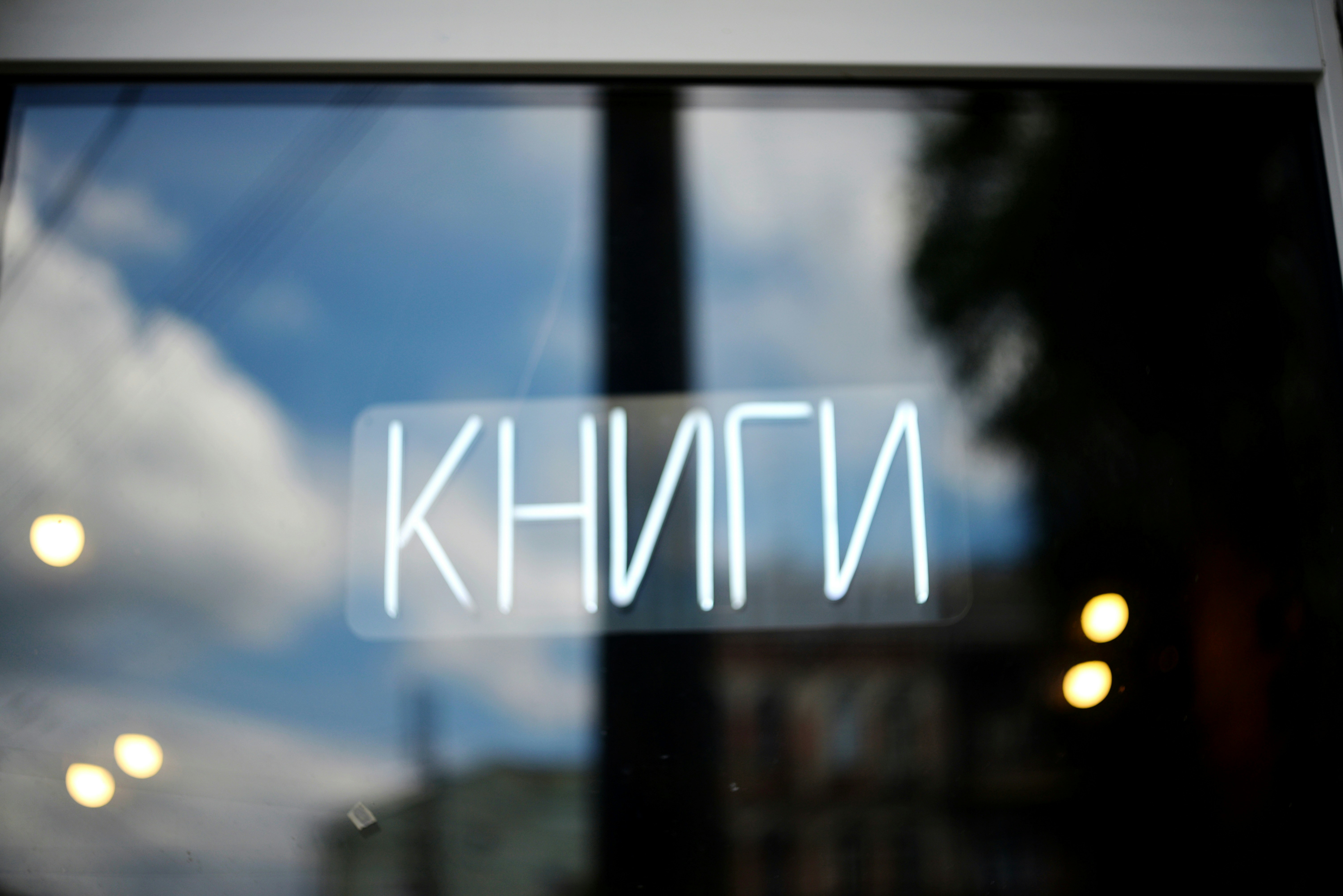 Glowing Cyrillic Sign Reflected in Shop Window