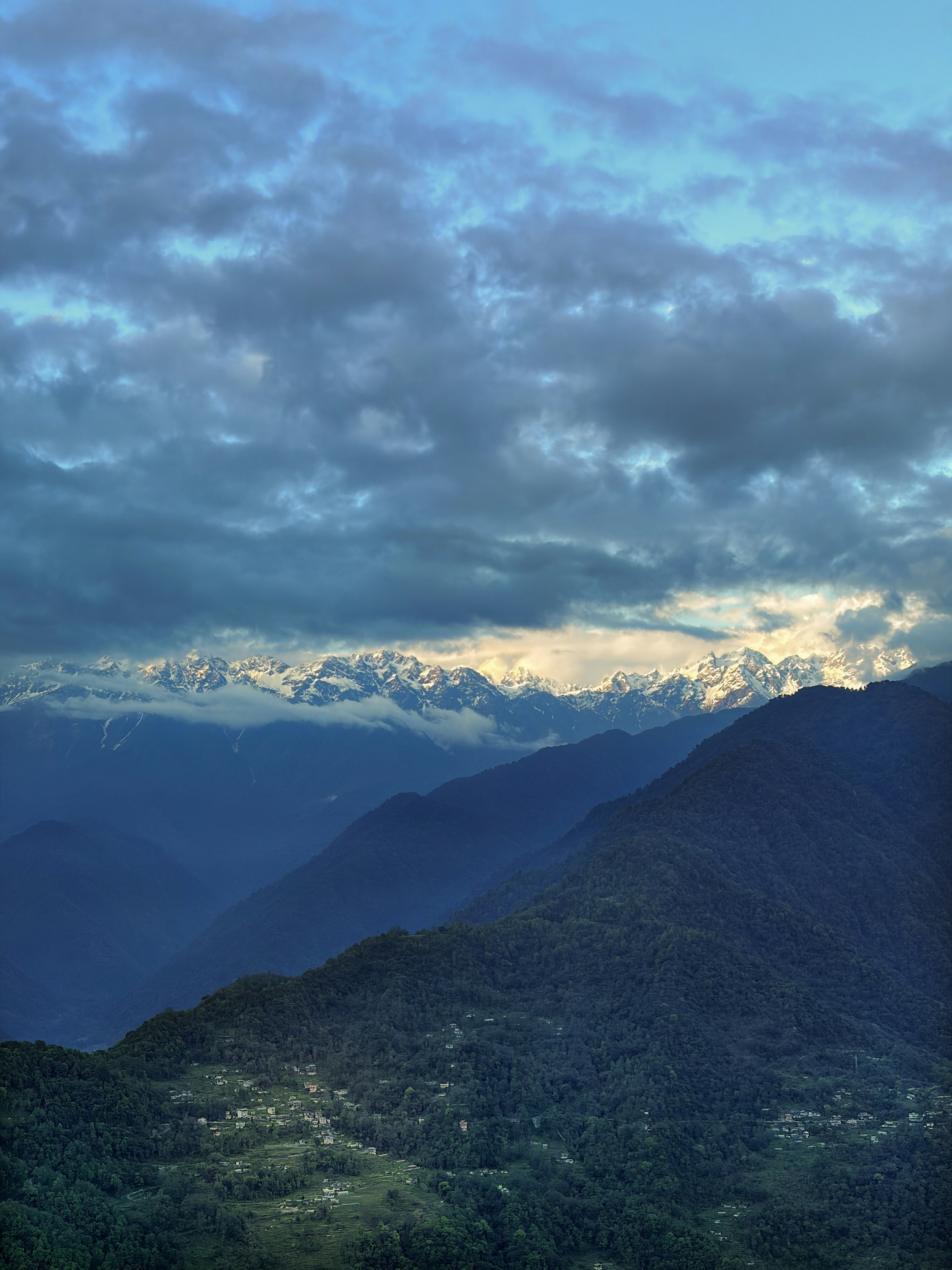 Dawn Veil Over the Ridge: Snow-Capped Peaks Beyond Verdant Slopes