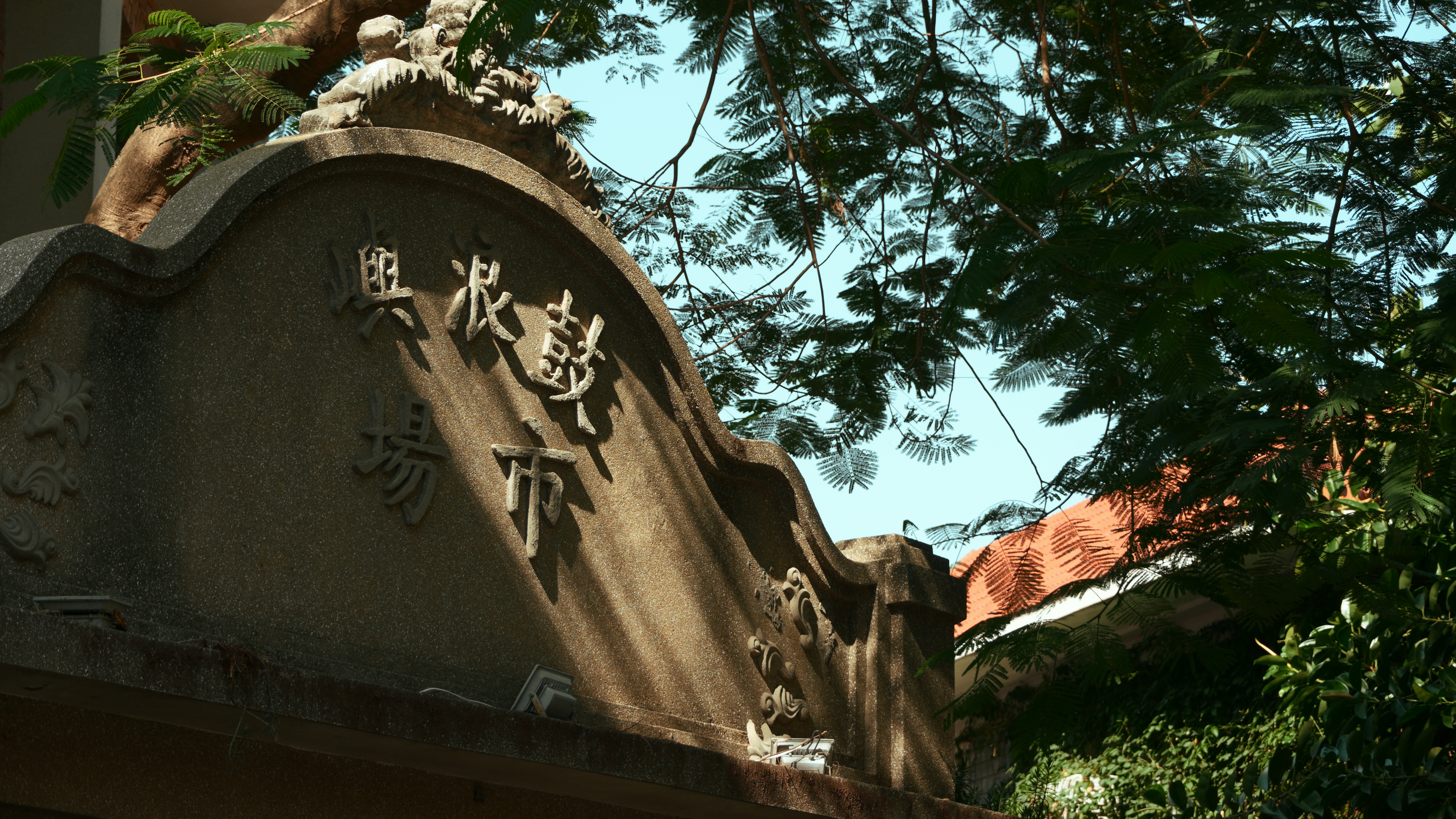 Stone Signage in Dappled Shade Beneath Overhanging Branches