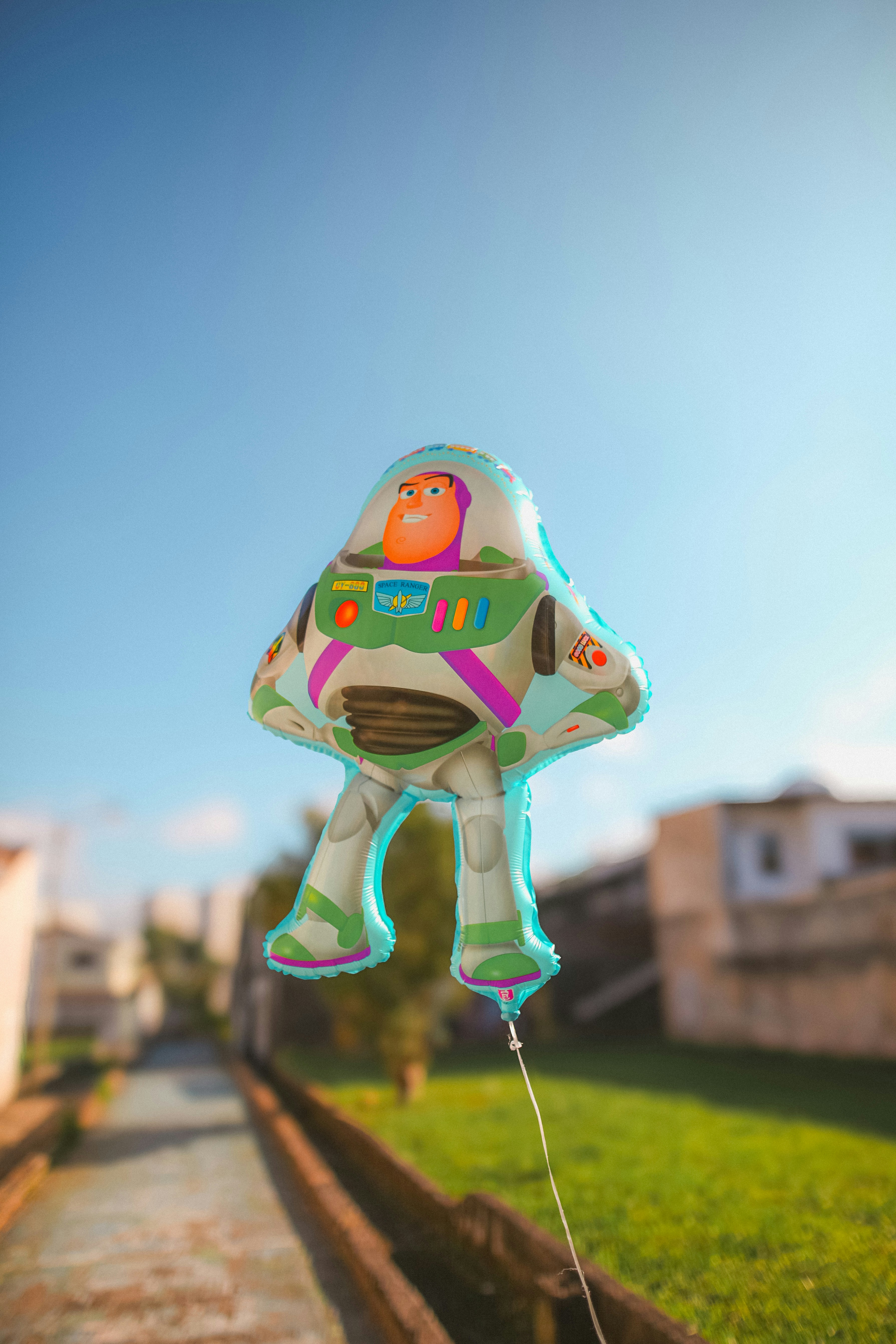 Buoyant Astronaut: Toy Balloon Lofts Over a Quiet Street