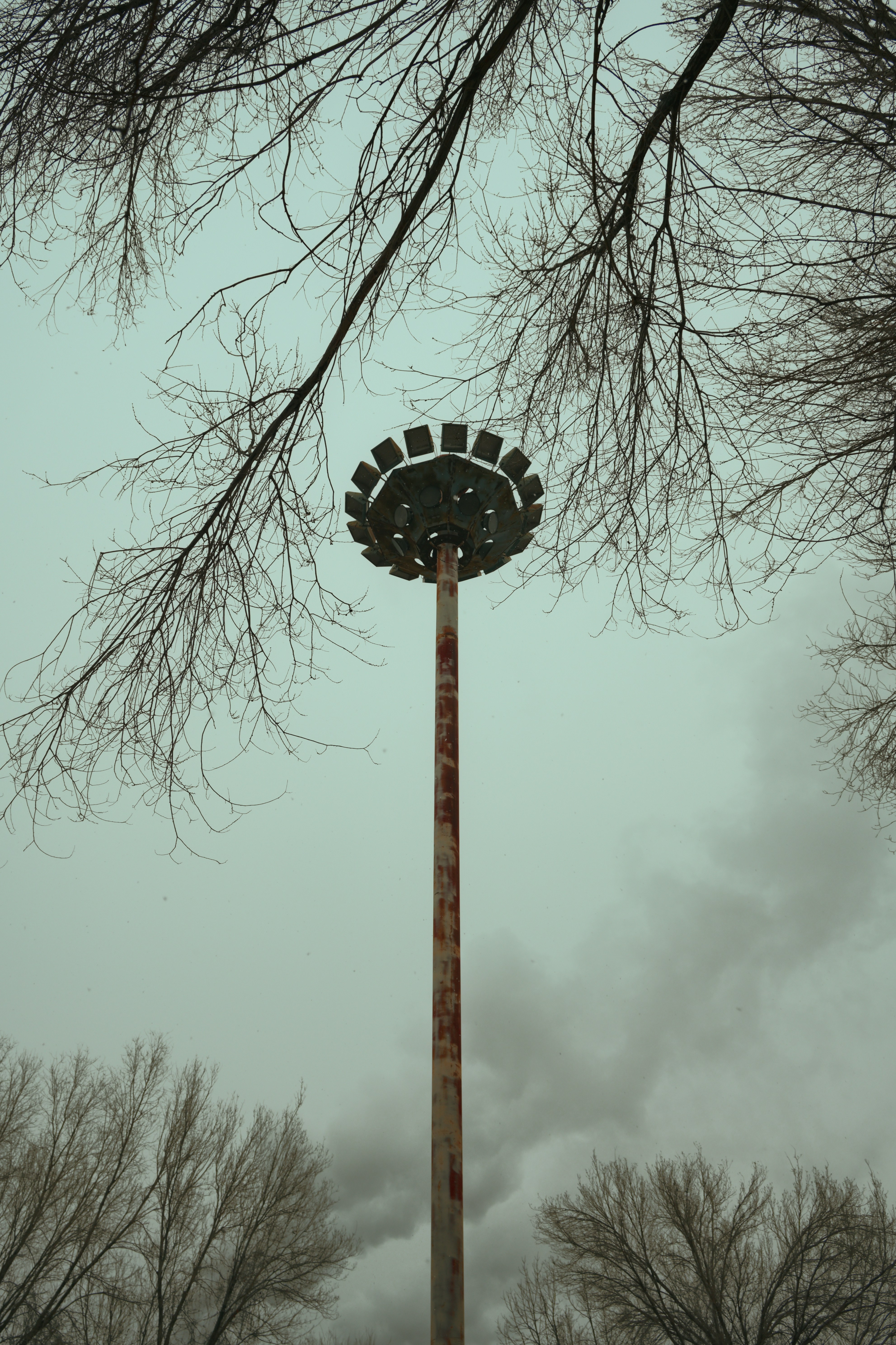 Towering Sentinel: A Rusted Pole Reaching Toward the Cold Sky