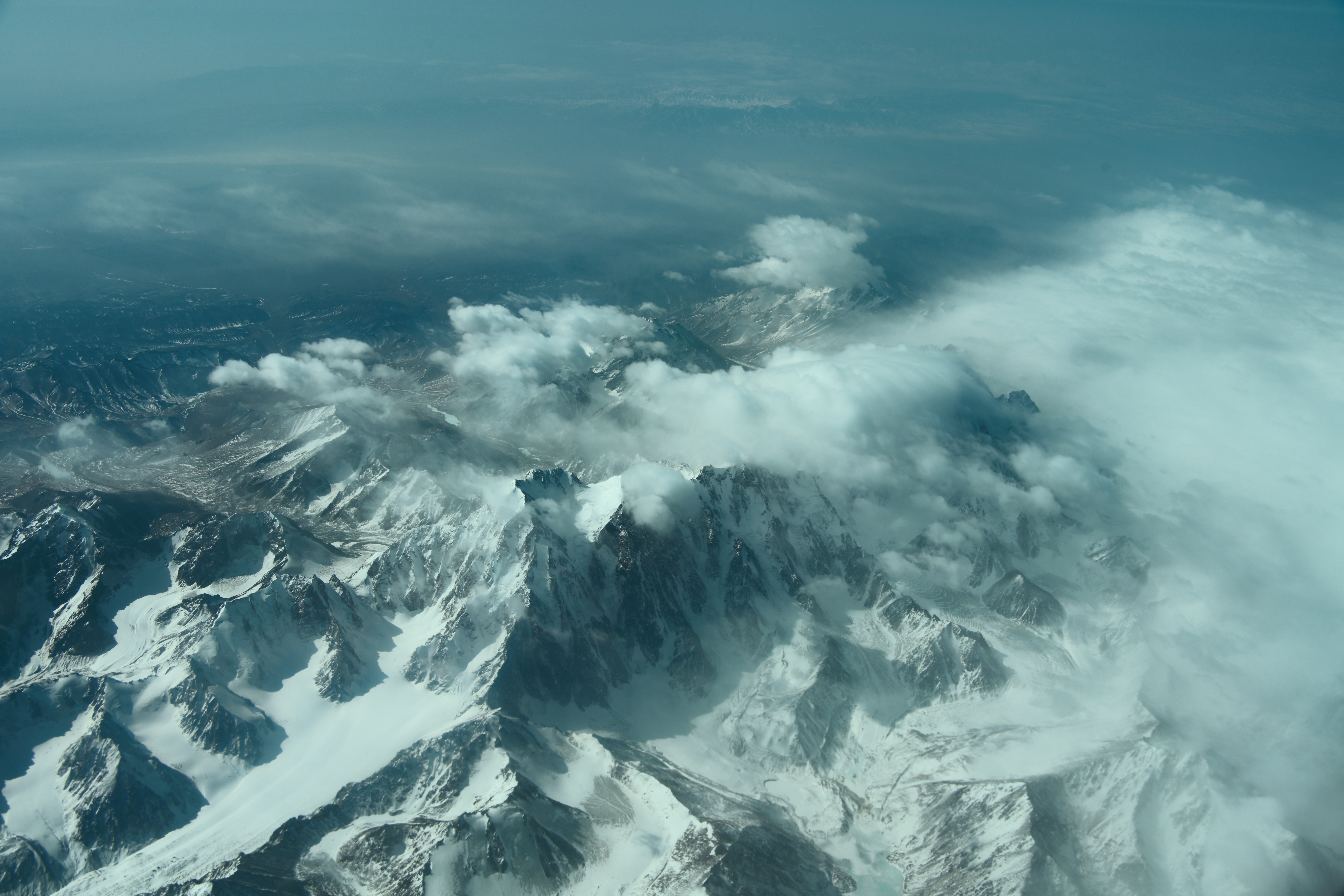 Edge of the Clouds: Snow-Crowned Peaks from Above