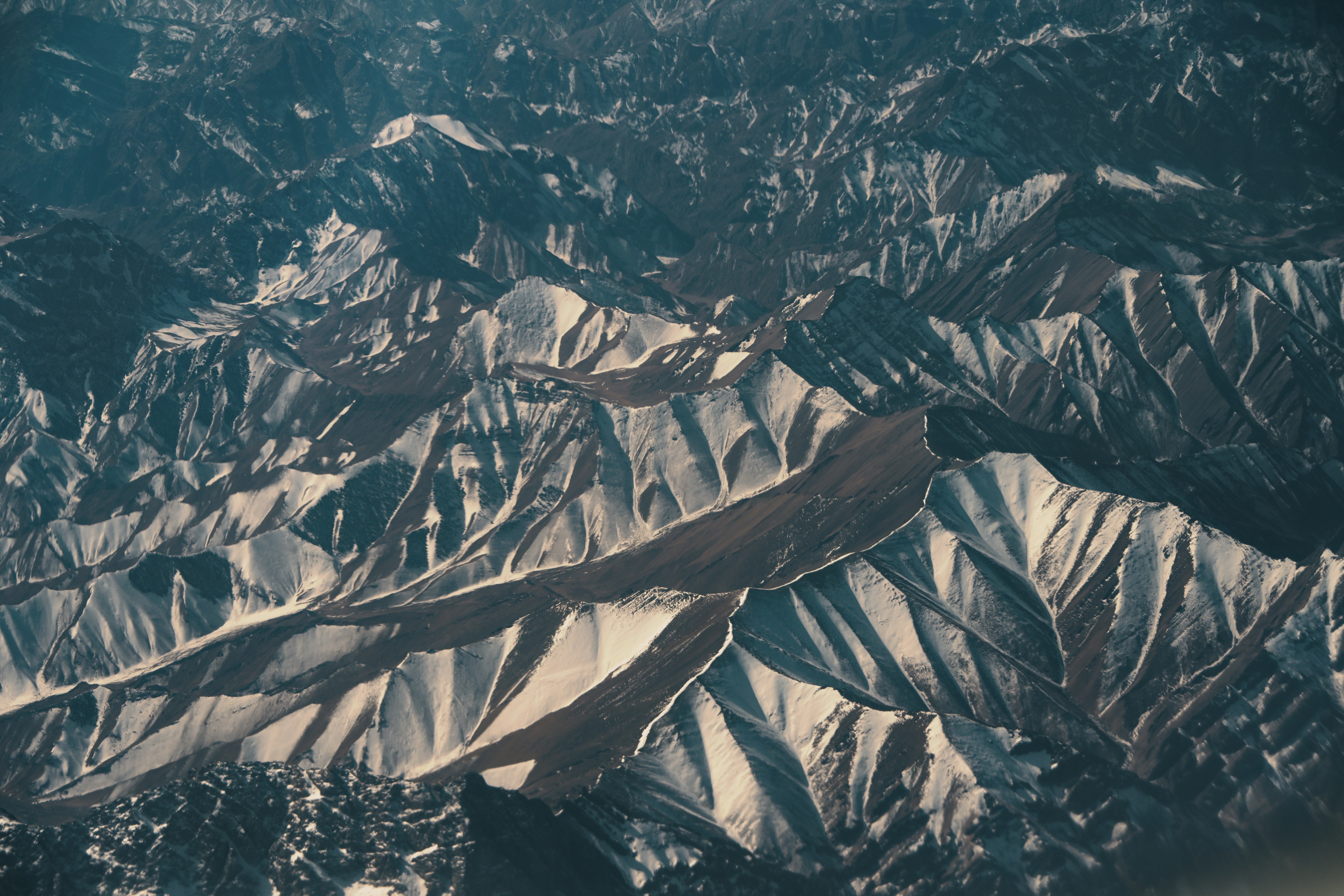 Aerial view of rugged snow-capped mountains.