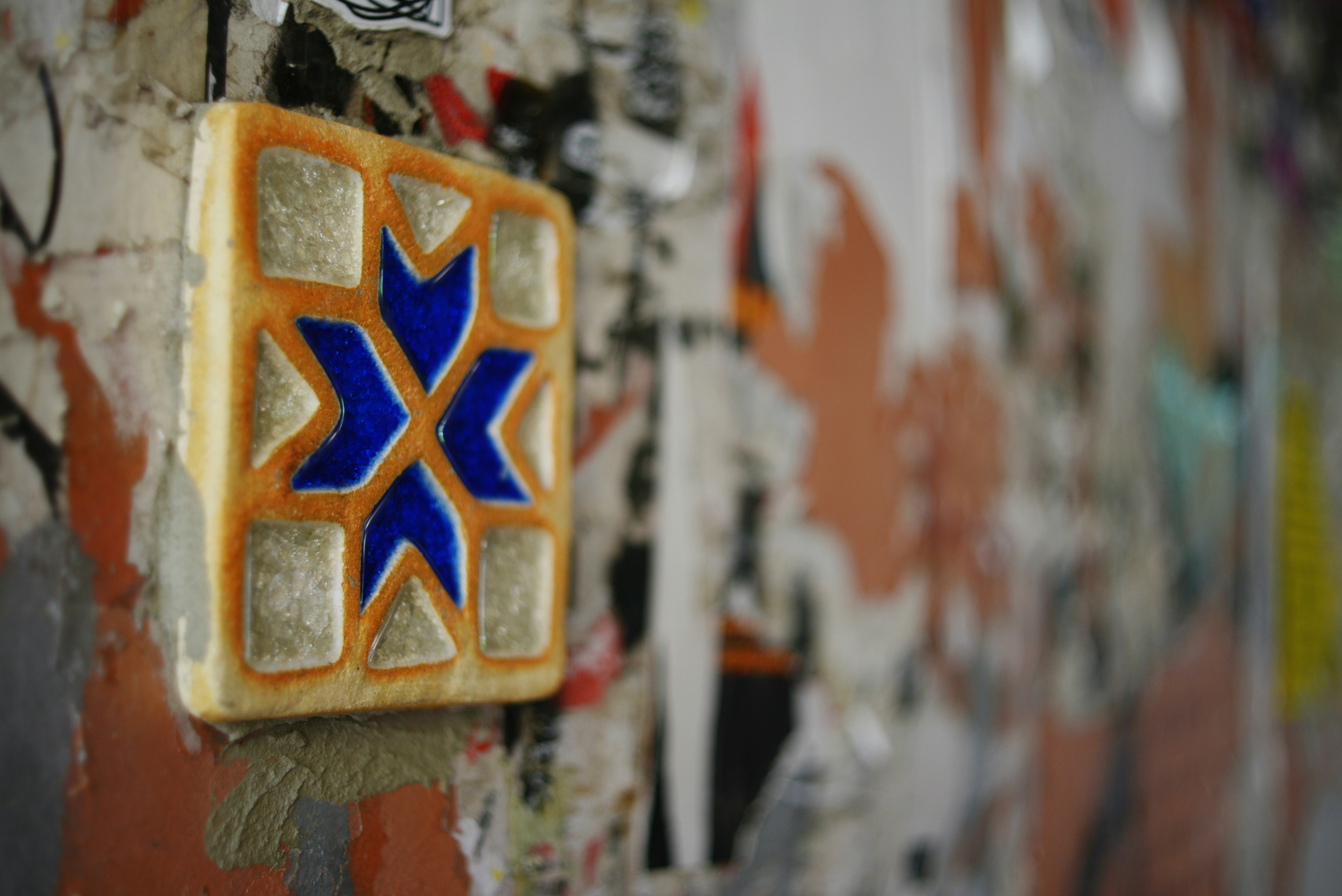 Square Tile Tag: A Neon-blue Star Amid Graffiti Mosaic
