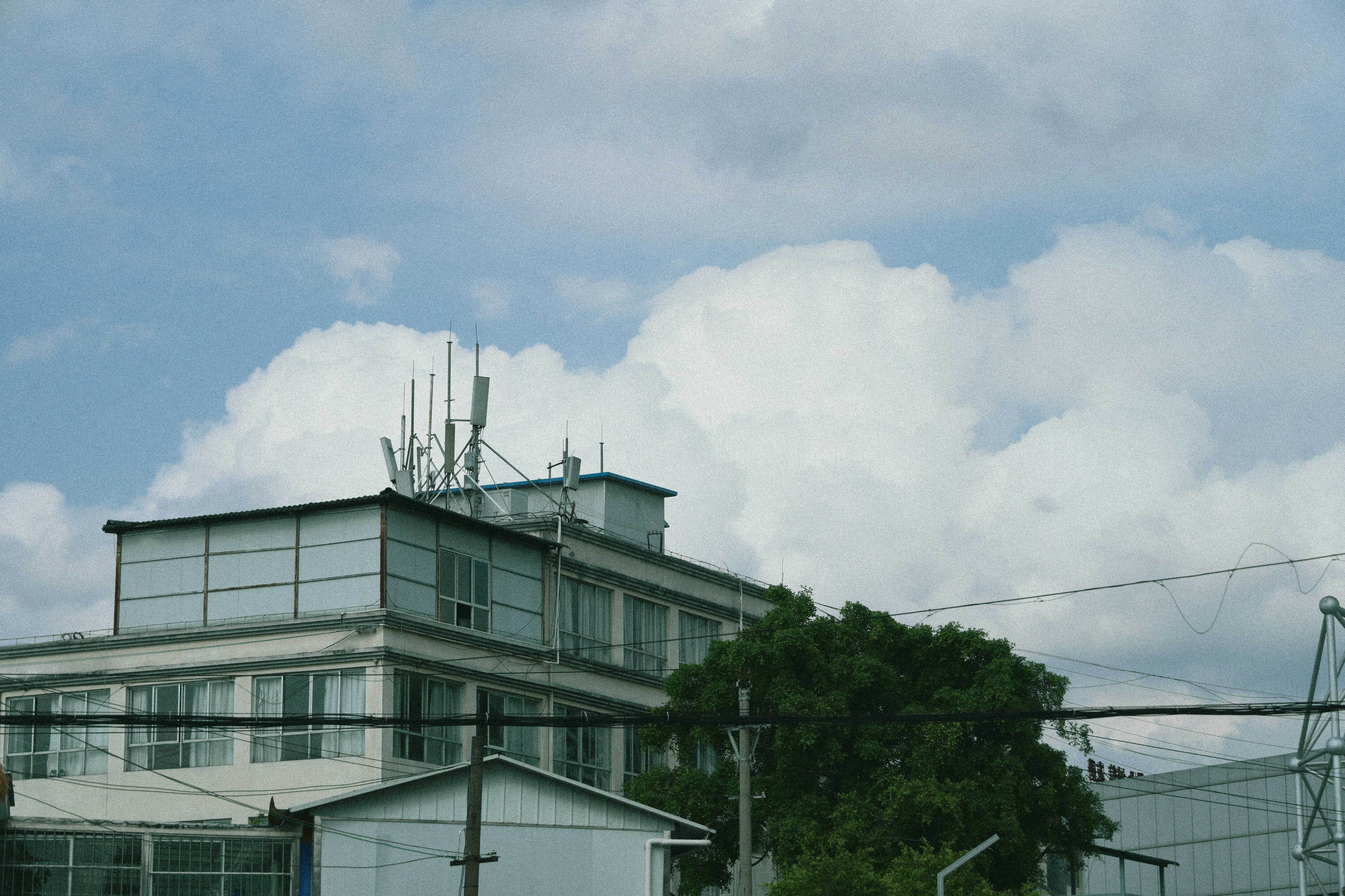 Industrial Rooftop Chorus under a Puffy Sky