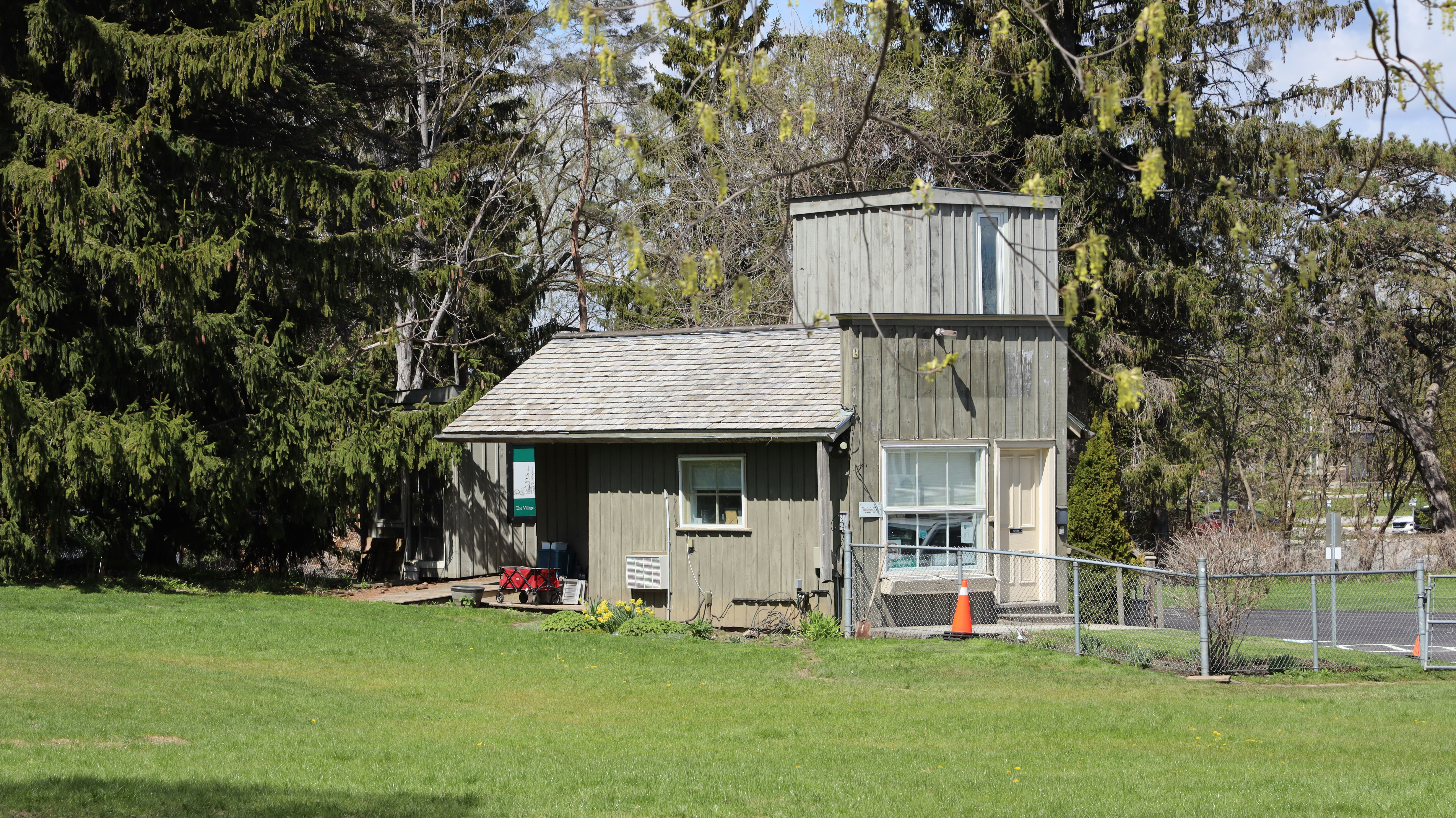 Weathered Control Cabin Framed by Green Field and Jeffing Fence