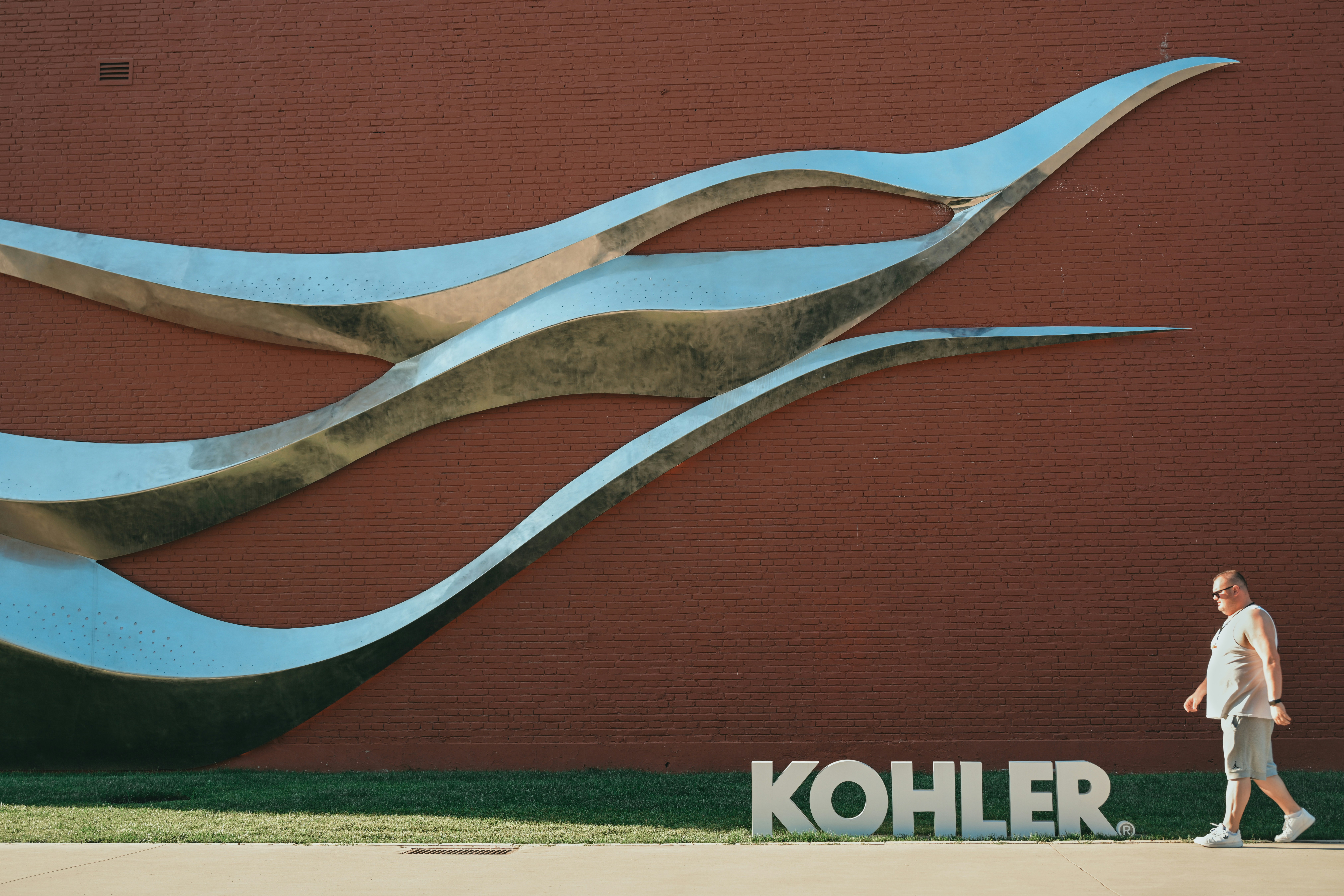 Flowing Metal Waves Against a Brick Backdrop