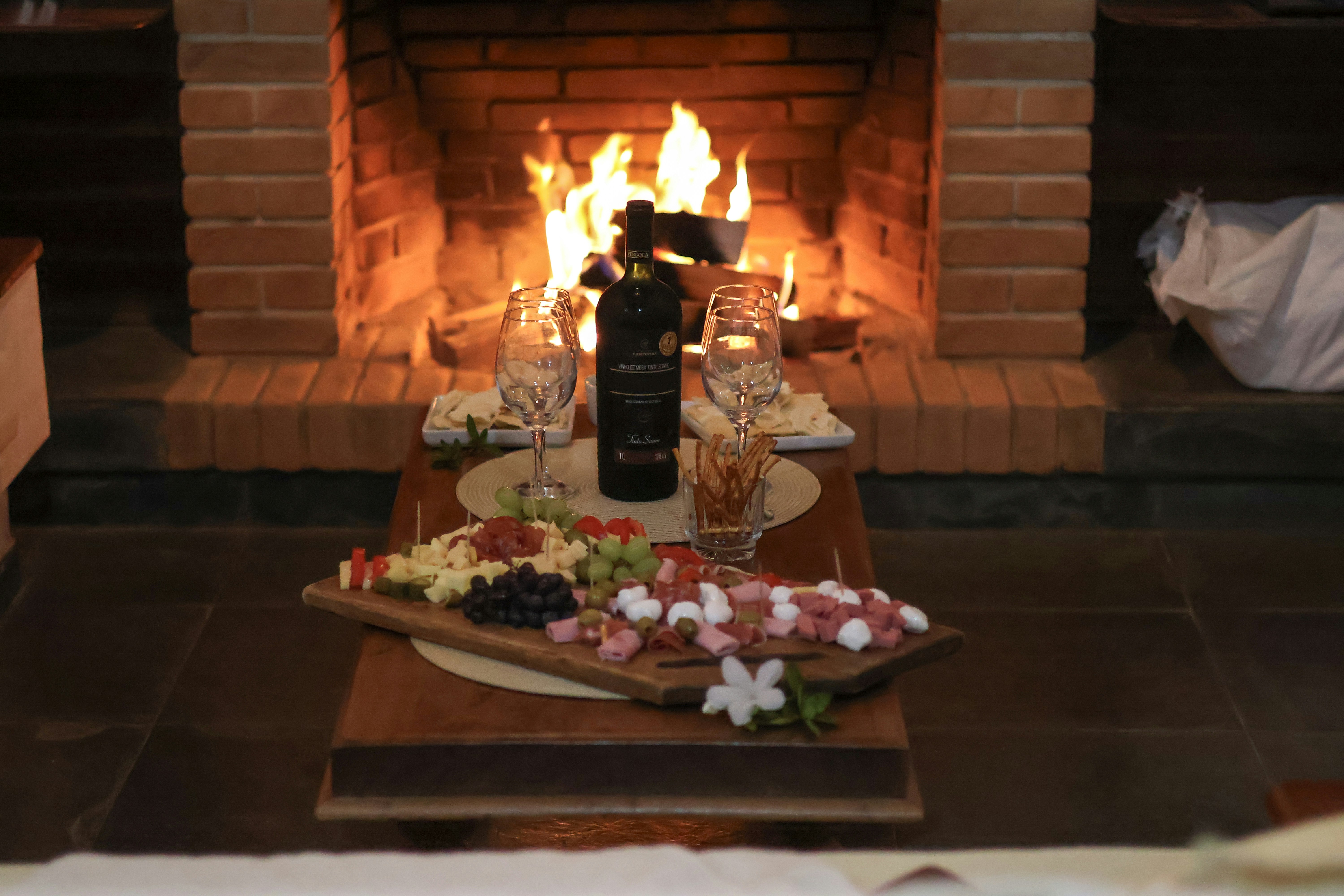 Warm Elegance on a Lodge Table: Wine, Cheese, and a Glowing Hearth