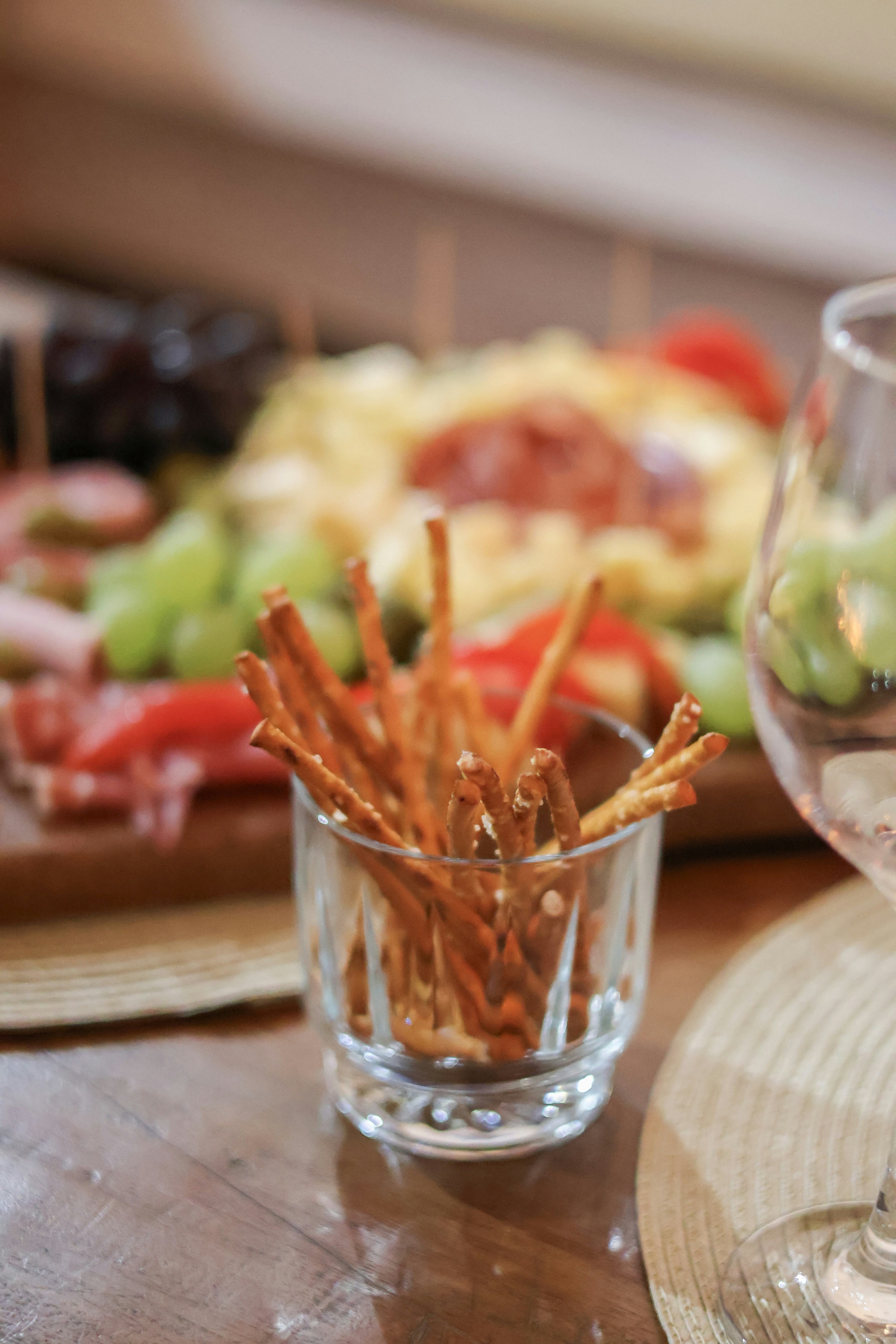 Close-up of gourmet breadsticks served alongside a charcuterie board and wine, creating a cozy and elegant dining experience in Gonçalves, Minas Gerais, Brazil.