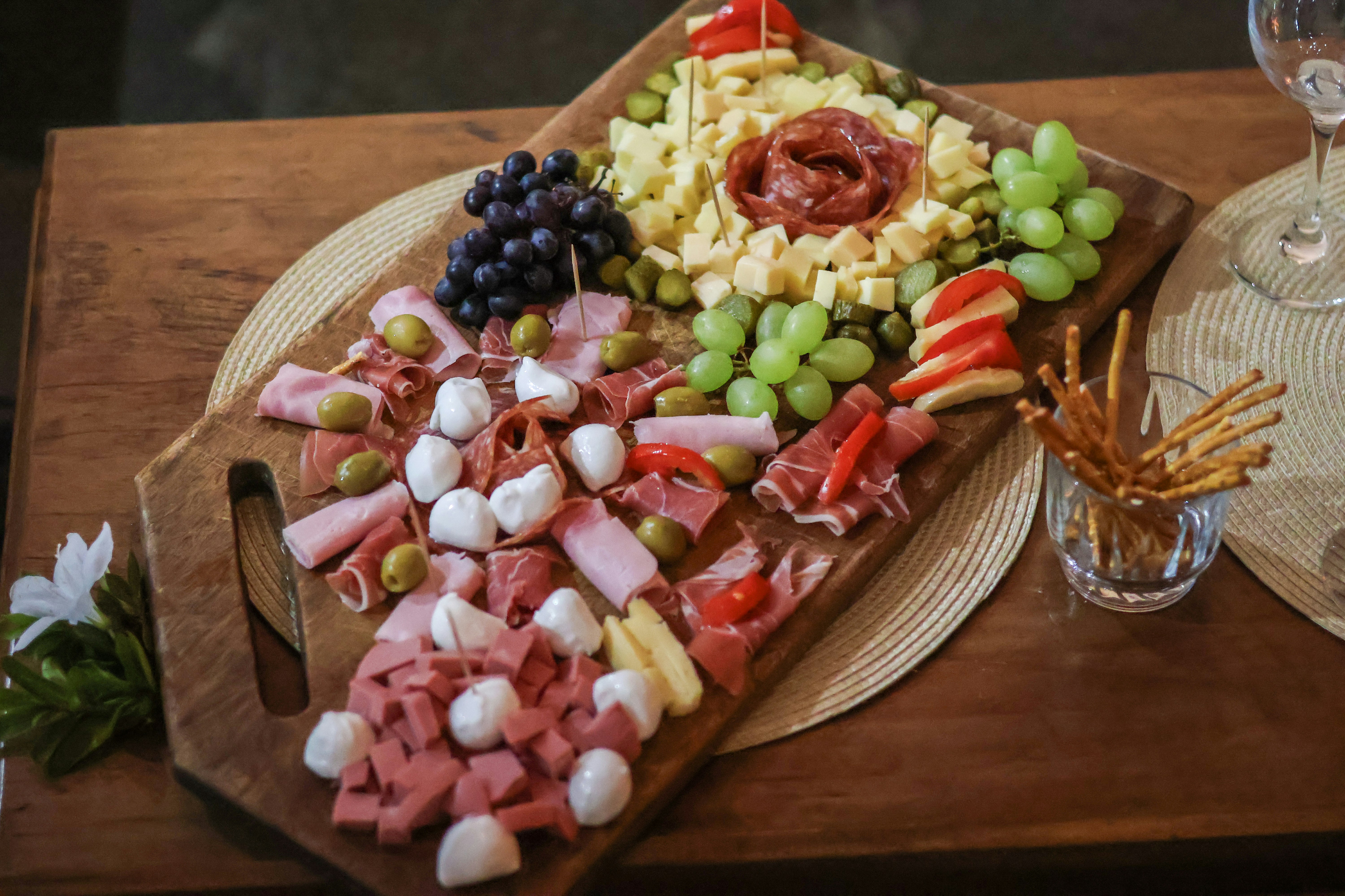 Artfully arranged charcuterie board with cheeses, meats, fruit, and appetizers served alongside wine in a cozy mountain retreat in Brazil.