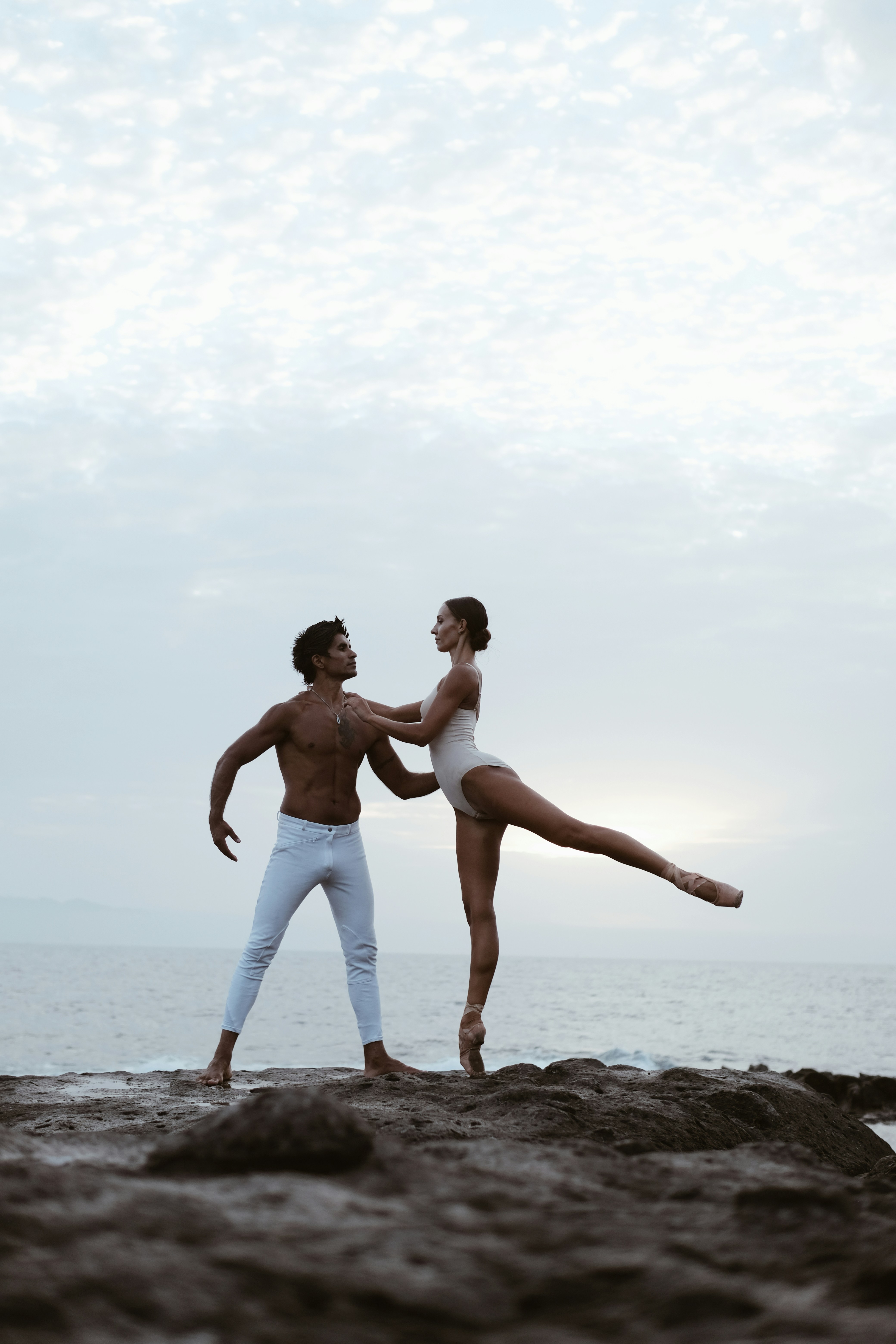 Balance on the Edge: Dancers in Dusk Over the Sea