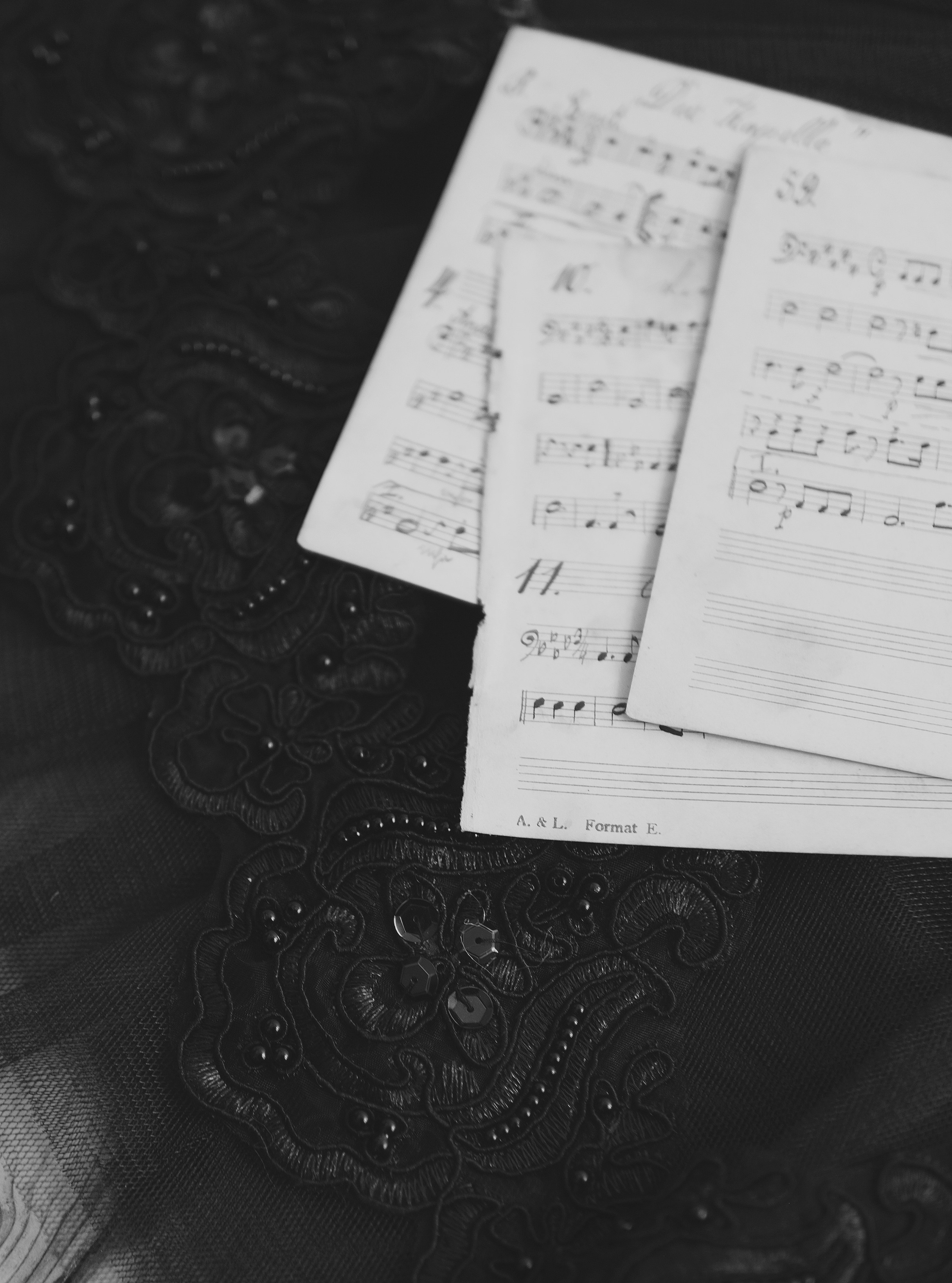 Sheet Music on Lace: A Quiet Study in Monochrome Textures