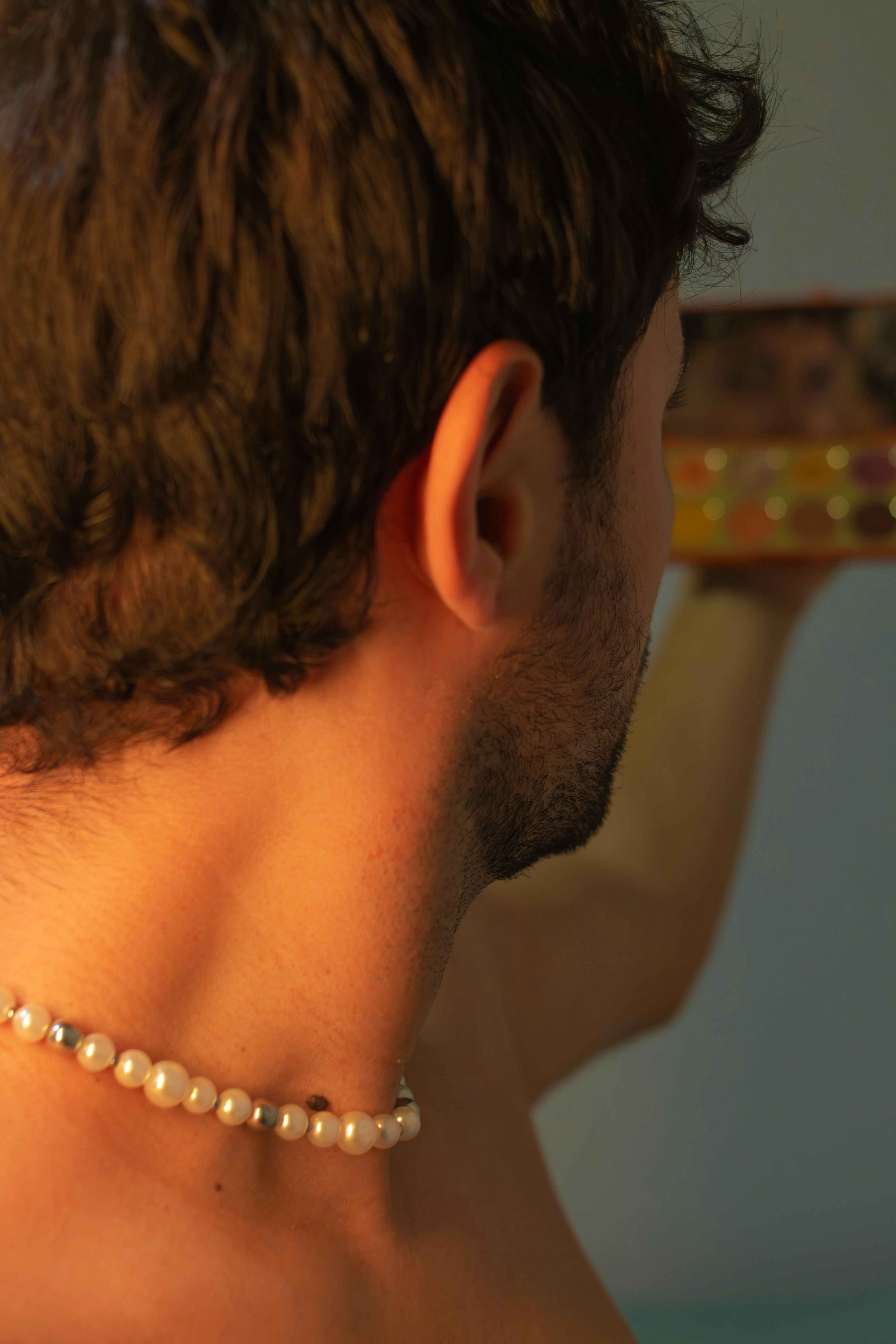 Side Profile in Warm Light: Pearl Necklace and Curved Silhouette
