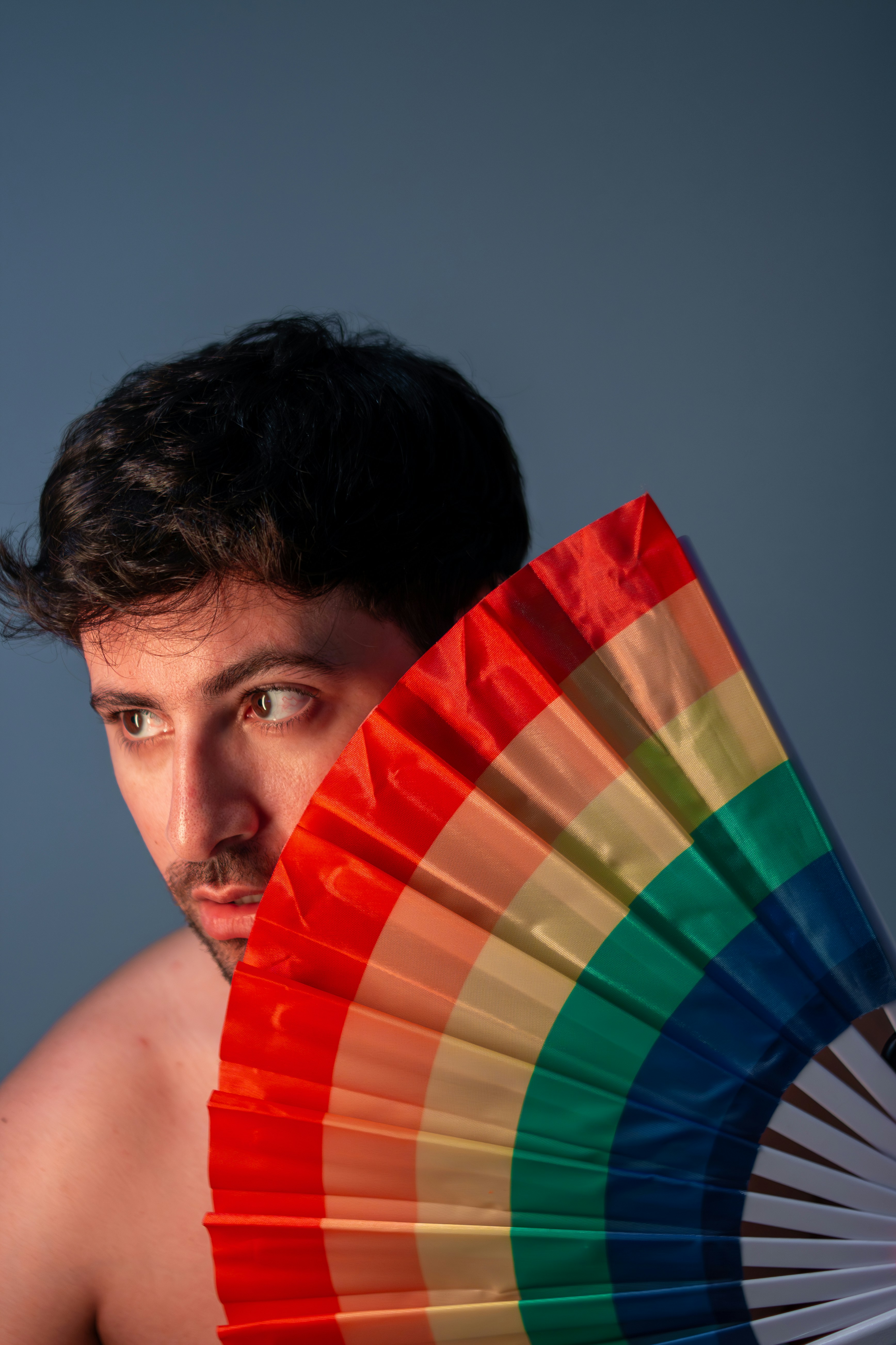 Partial Face in Focus: A Portrait with a Rainbow Fan