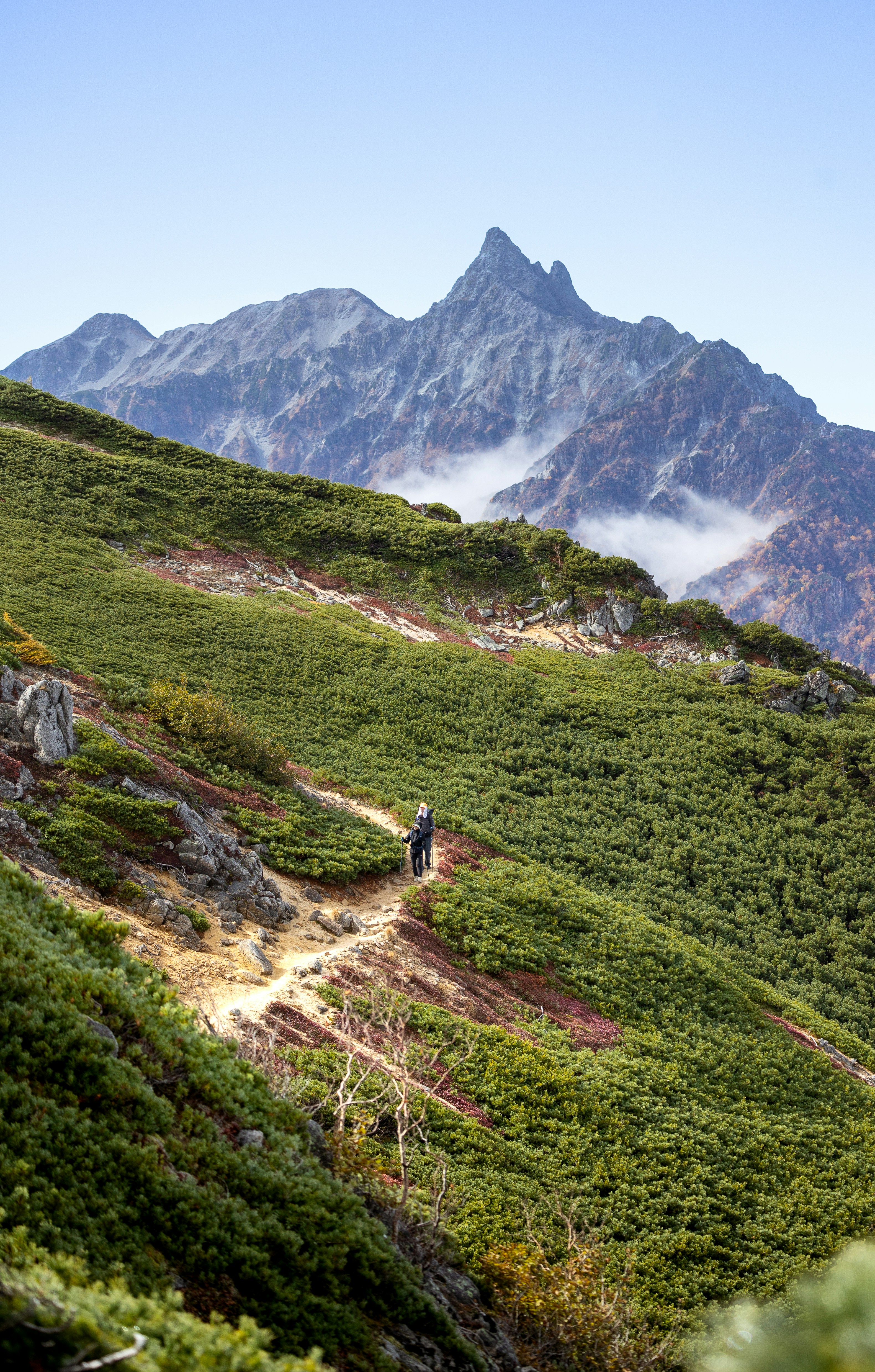 Hiker’s Ascent Beneath Jagged Peaks