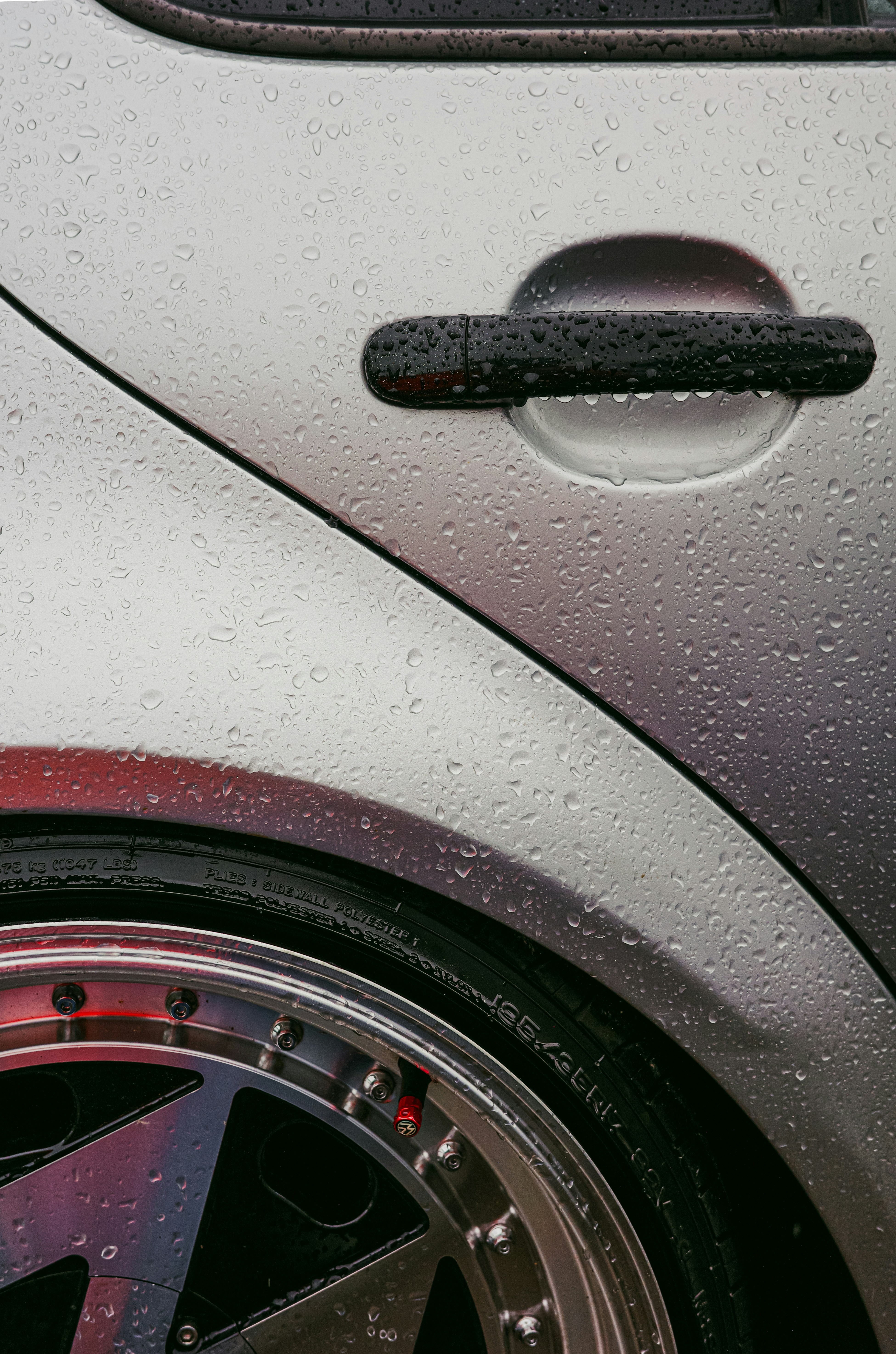 Raindrops on a Metallic Curve: A Car's Quiet Moment in the Rain