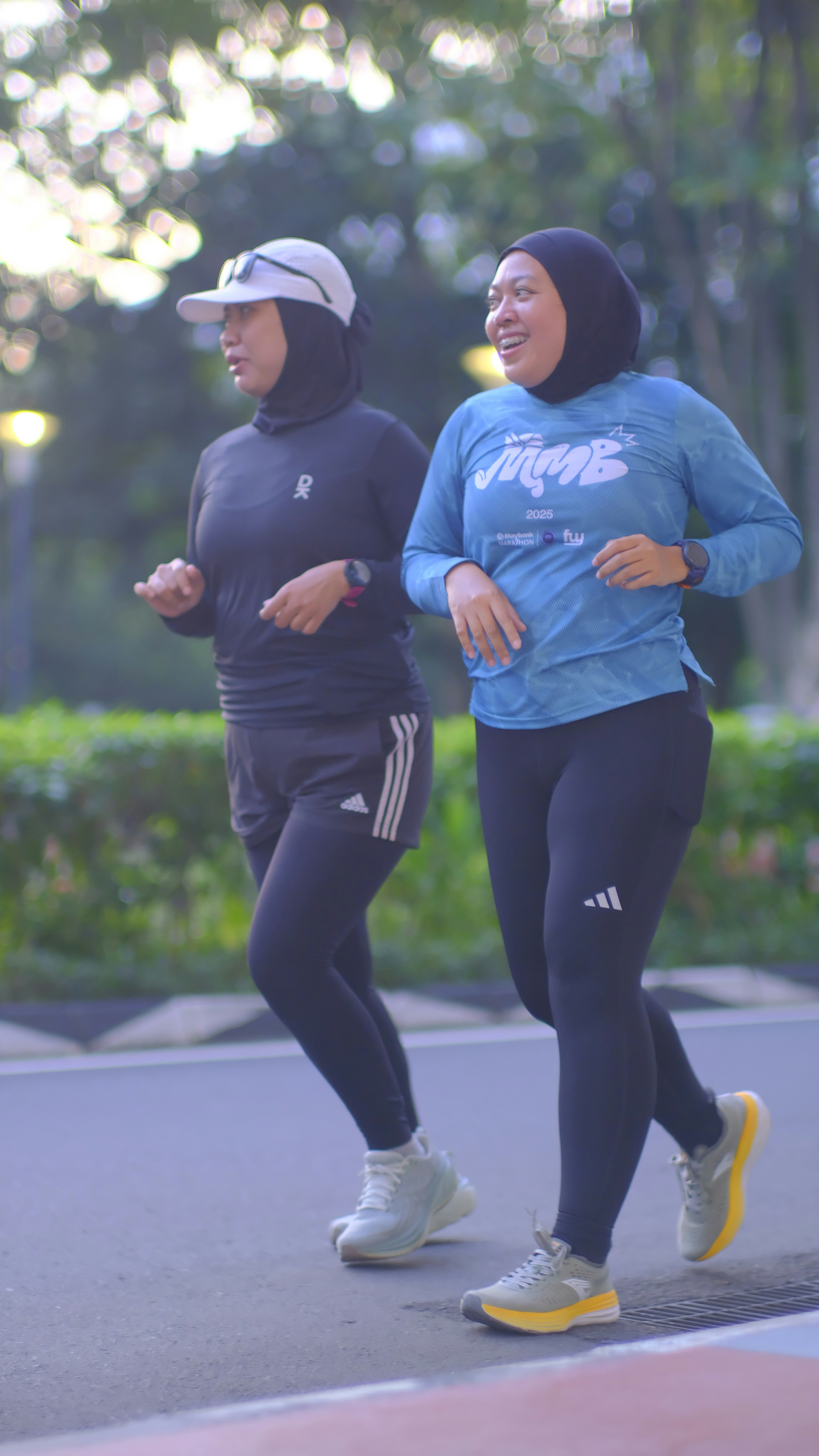 Two women in hijabs jogging outdoors.