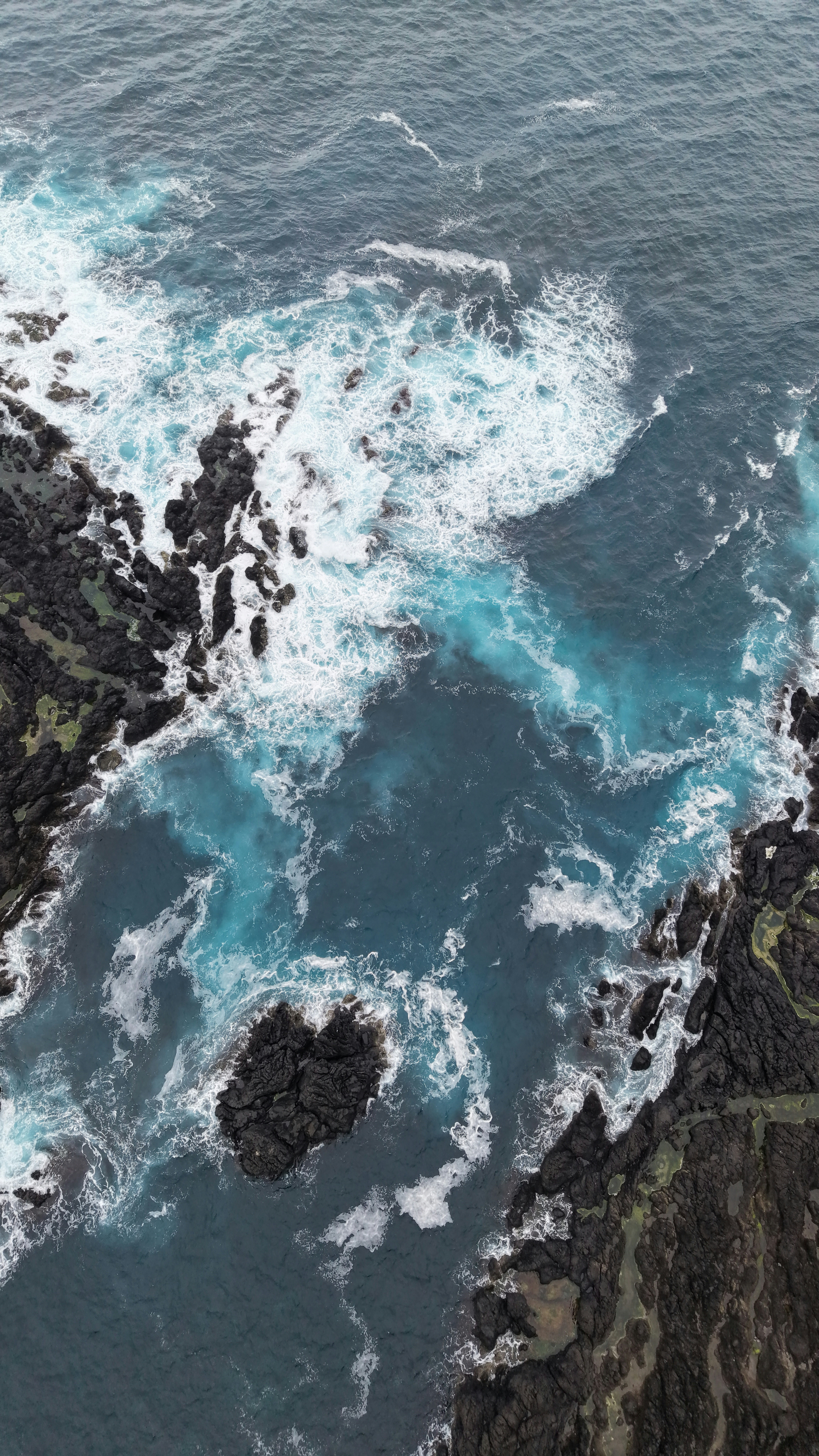 Azure Crevices: Aerial Rivulets Carving Through Jet-Blue Rock