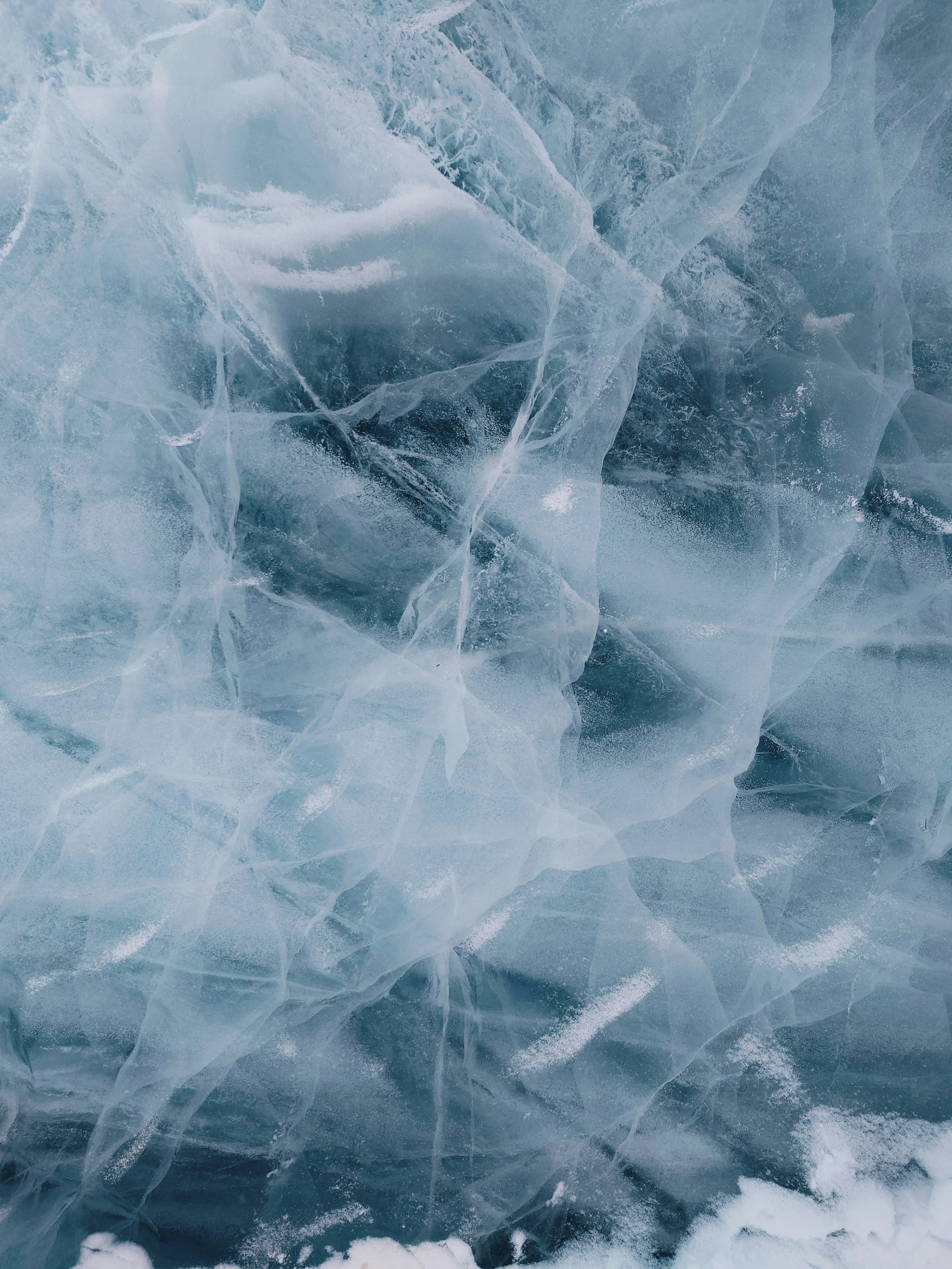 Cracked blue ice surface with intricate patterns and textures.