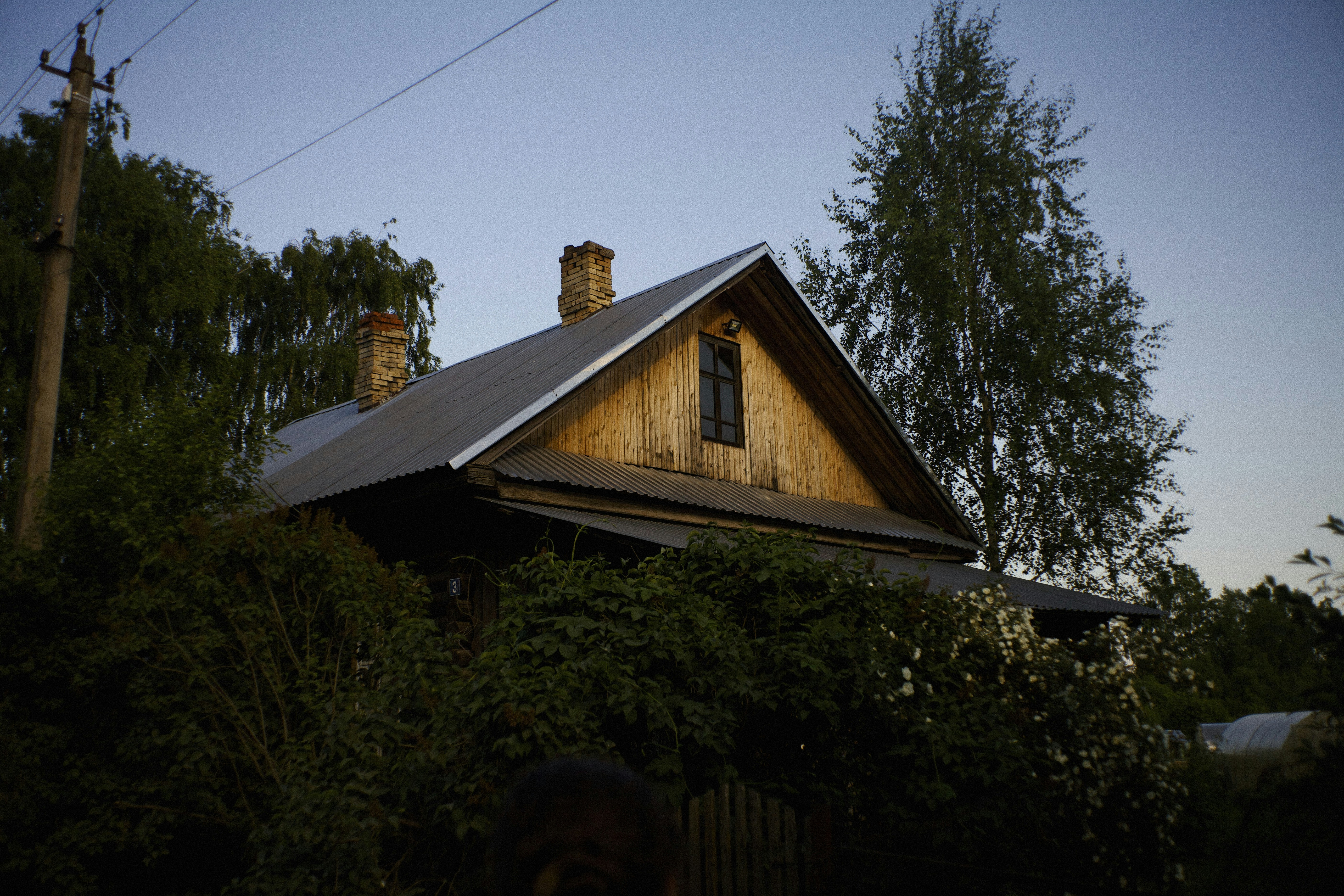 Sunlit Attic Gable: Warm Light on a Quiet Rural House