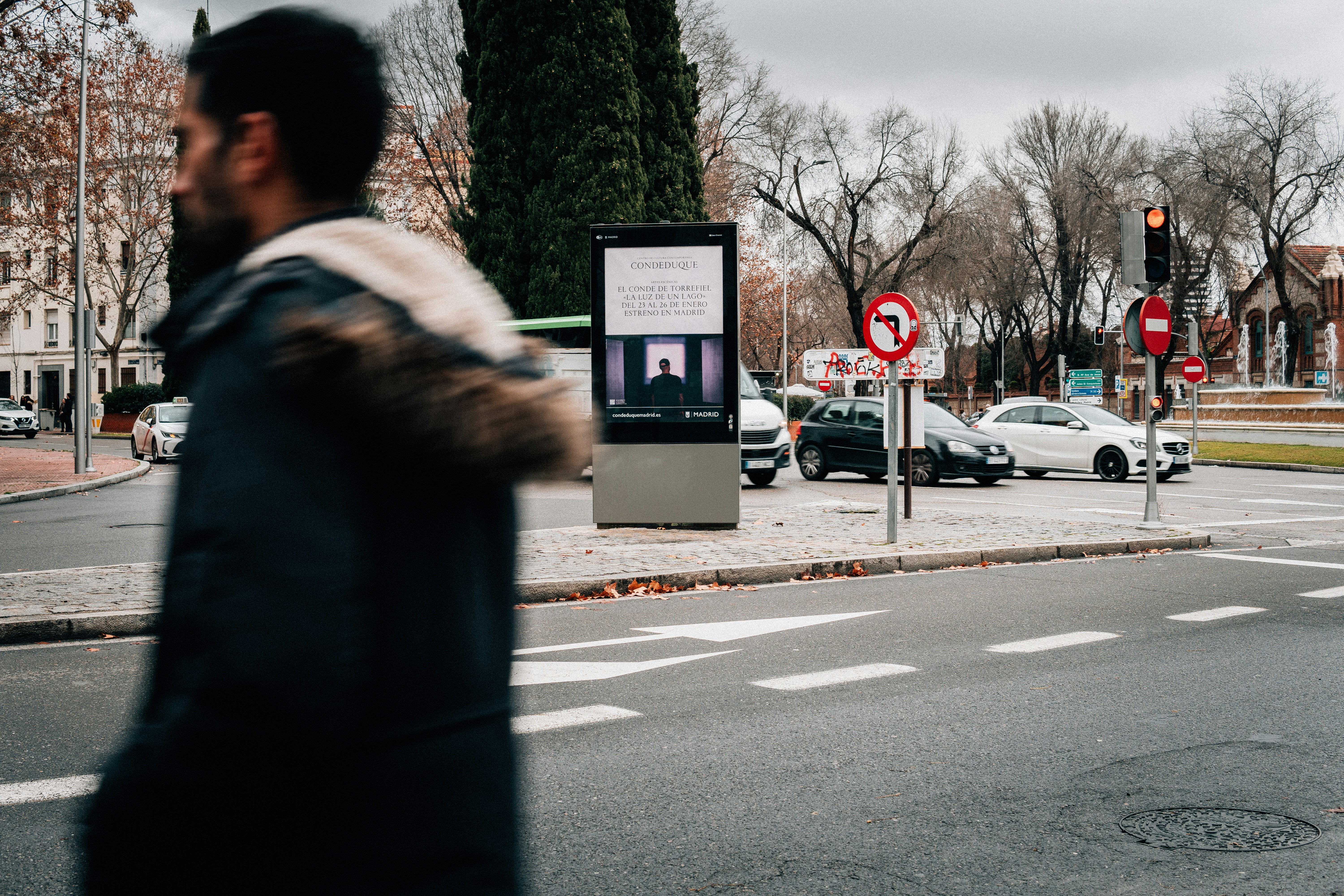 Crosswalk Moment: A Blurred Pedestrian Passes a Calm Street Scene