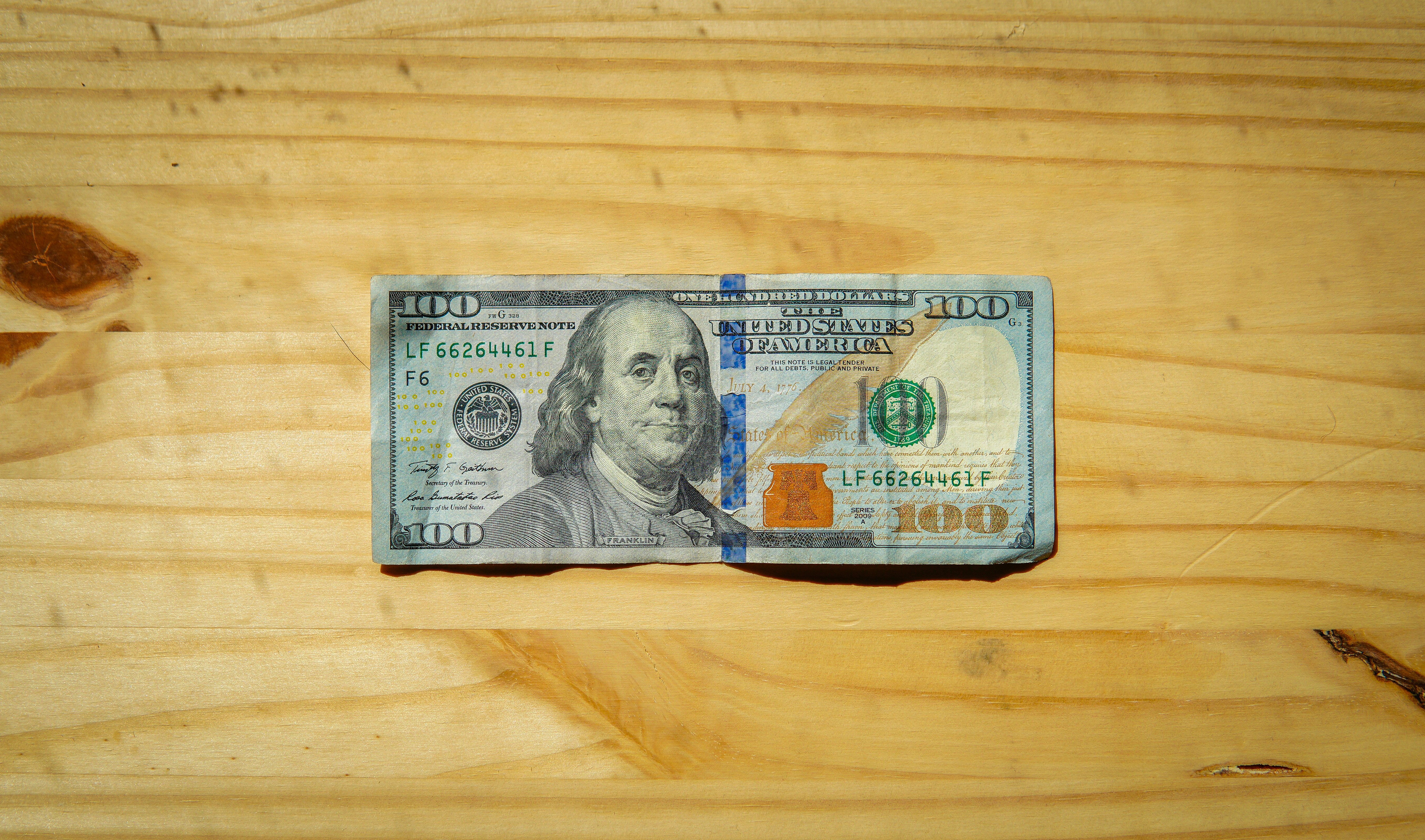 Folded Century: A Crumpled Hundred Quietly Framed on Pine