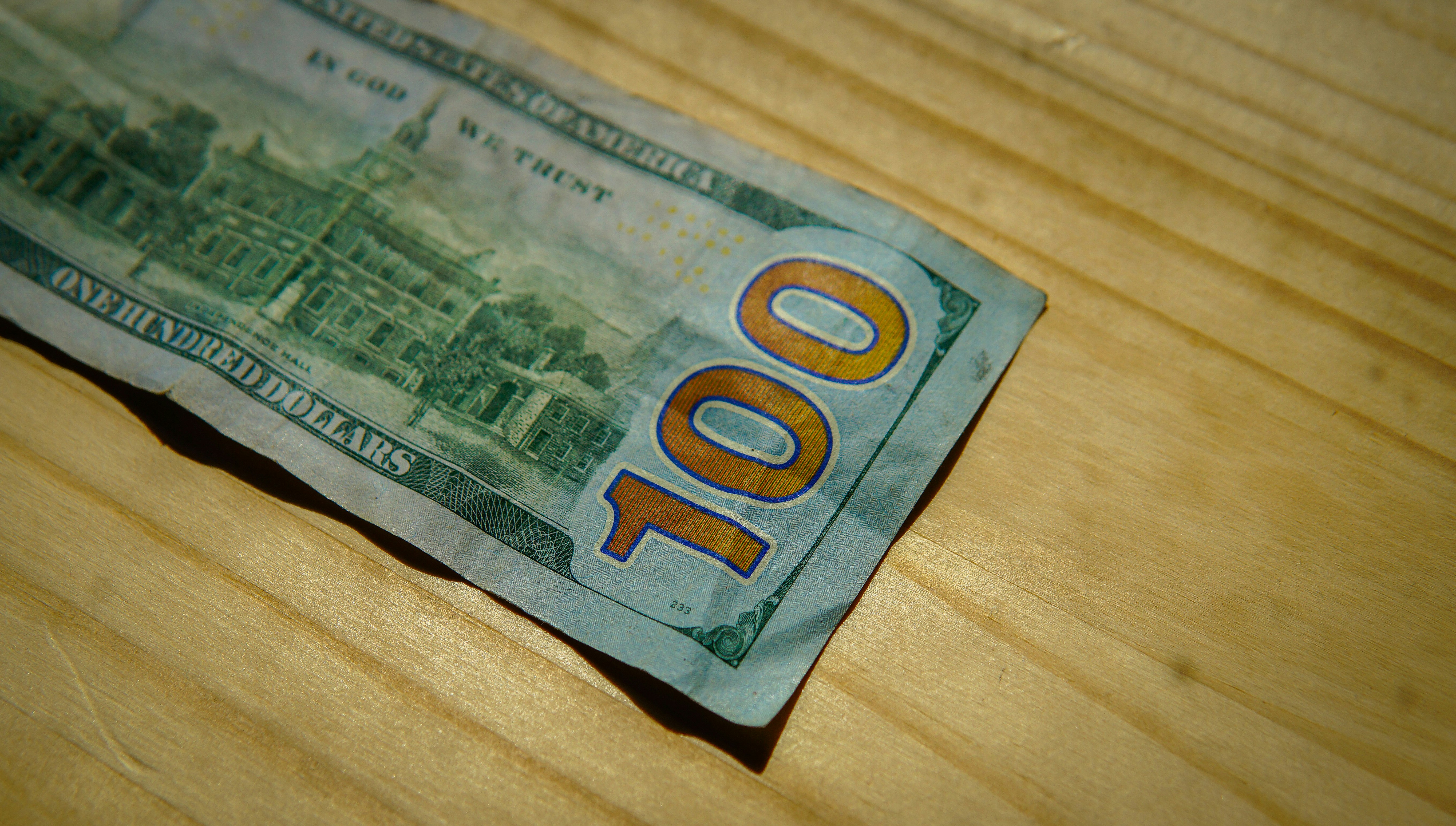 Hundred-Dollar Corner: A Torn Edge on a Wooden Surface