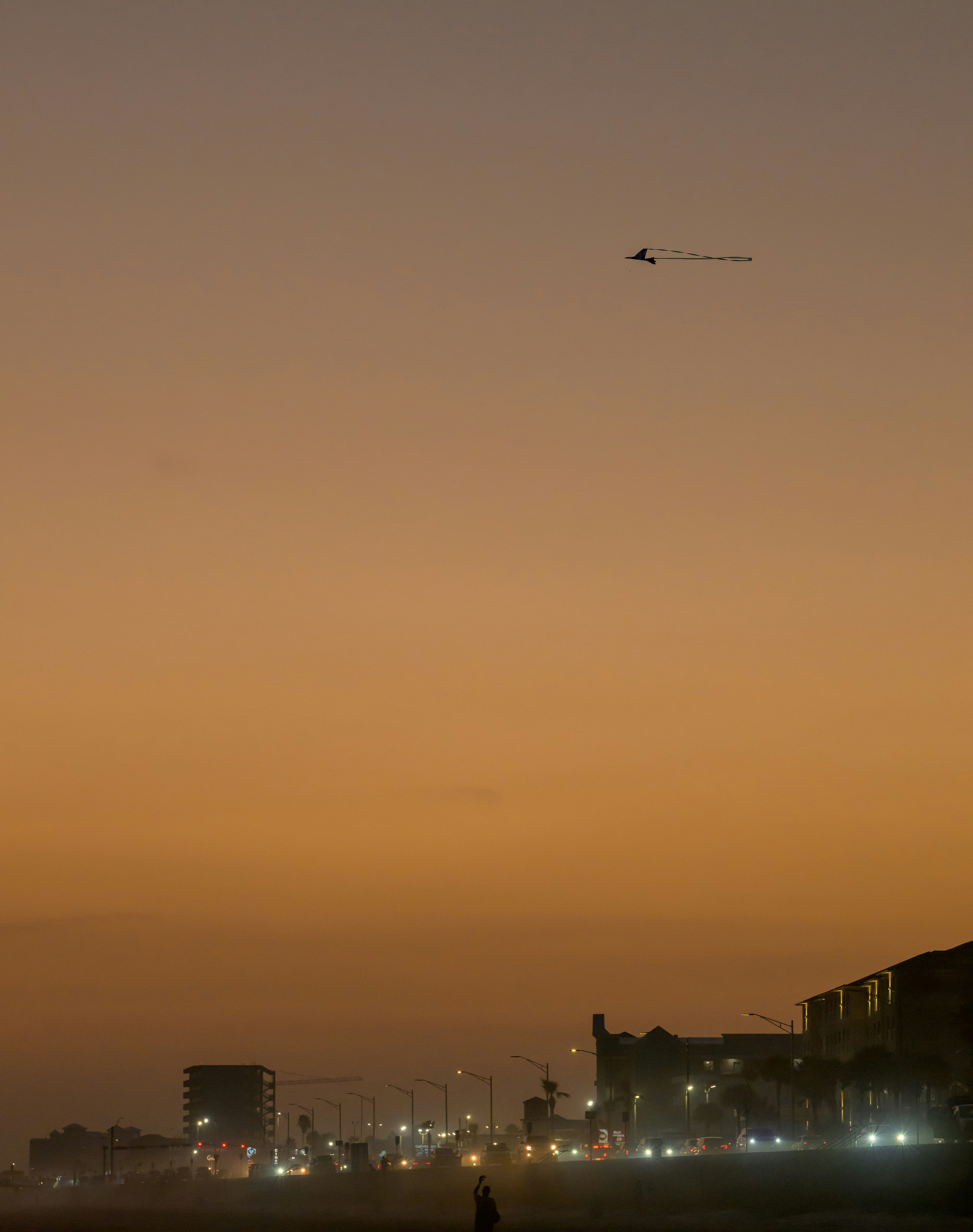 Dusk Vigil: A Lone Silhouette Above a Quiet Coastal City