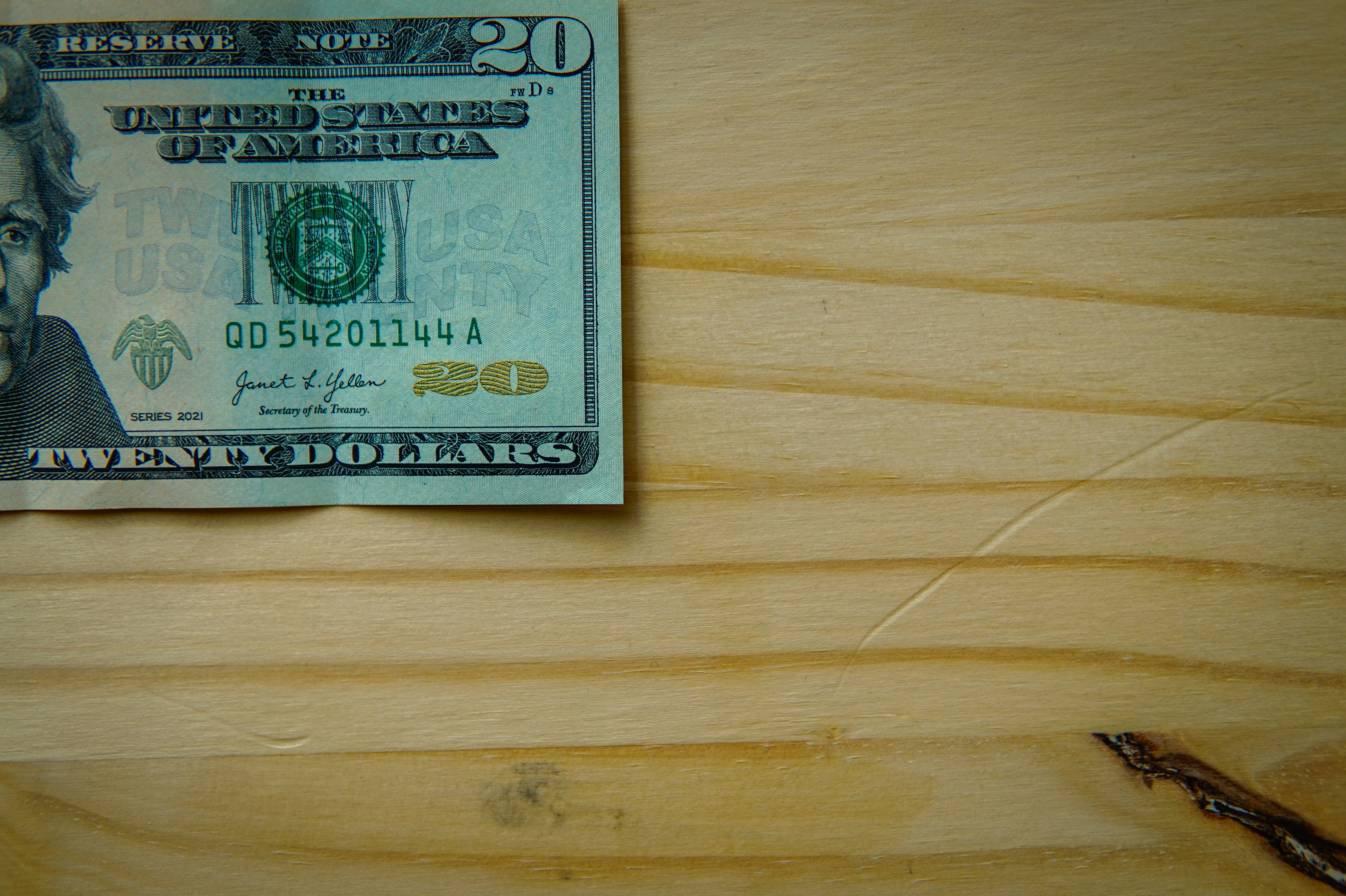 Frayed Corner: A Cut of Greenback on a Wooden Desk